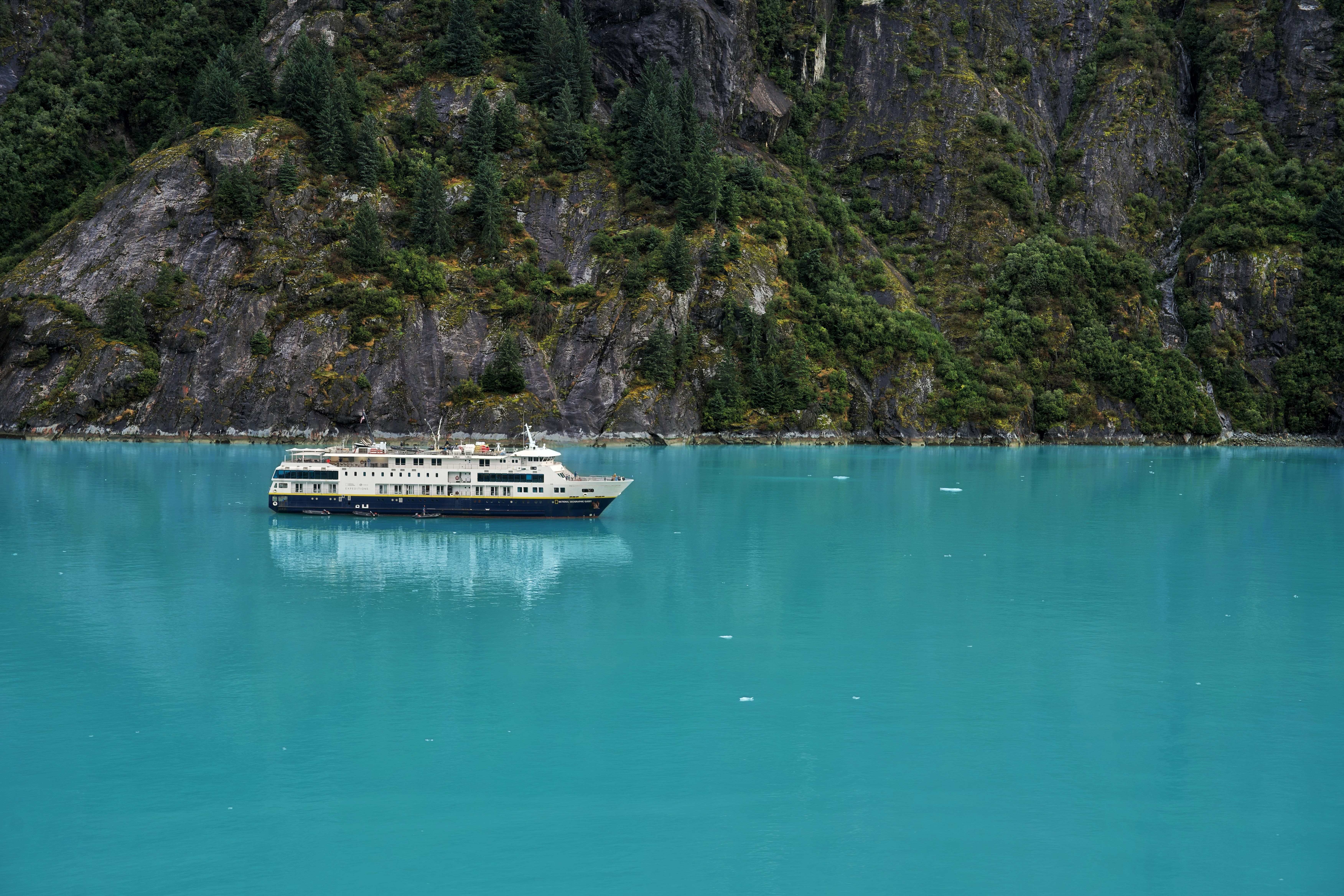 Turquoise Fjord Crossing: A Yacht Amid Alpine Stillness