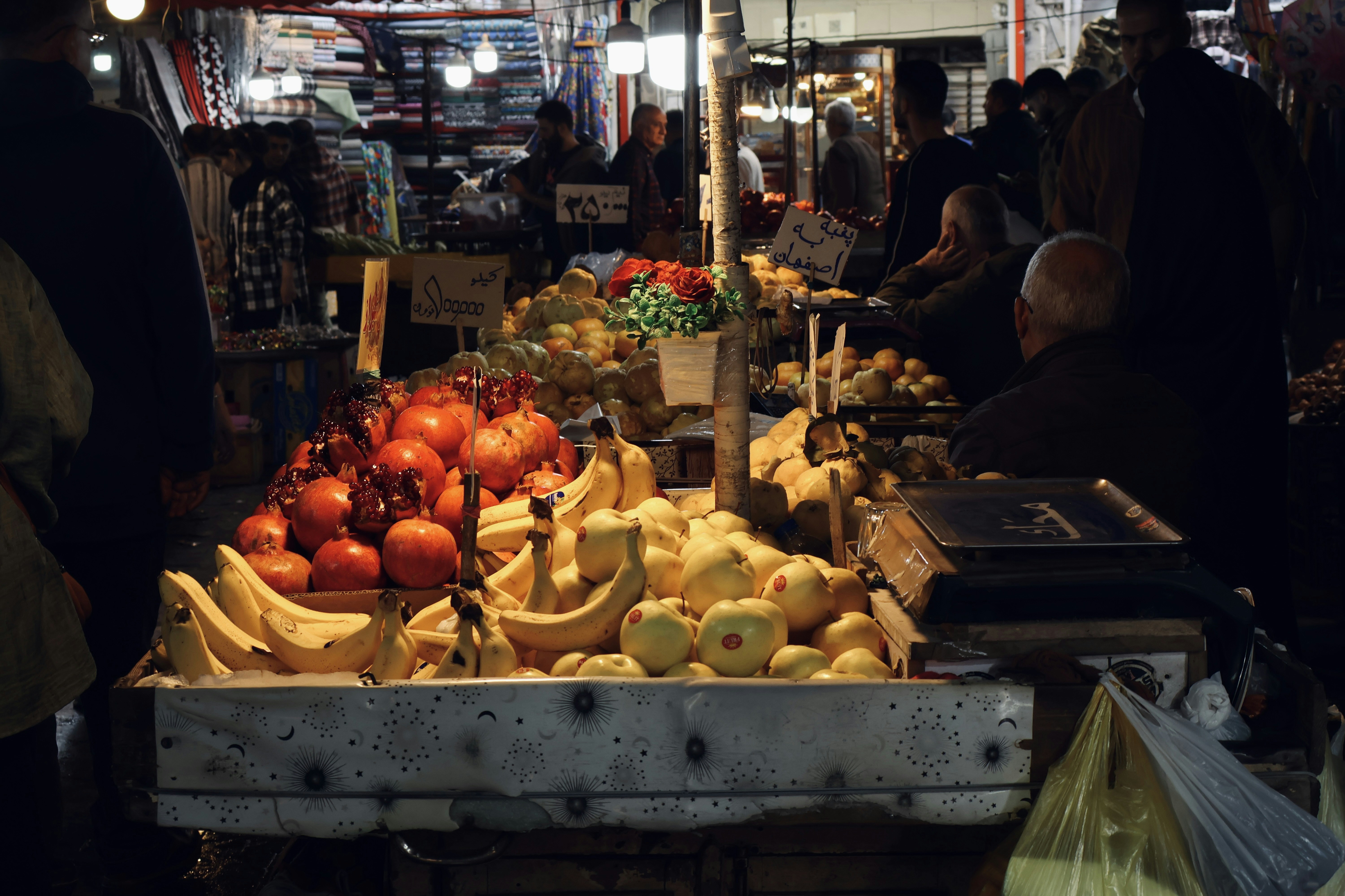 Vibrant fruit stall under market lights, a culinary mosaic