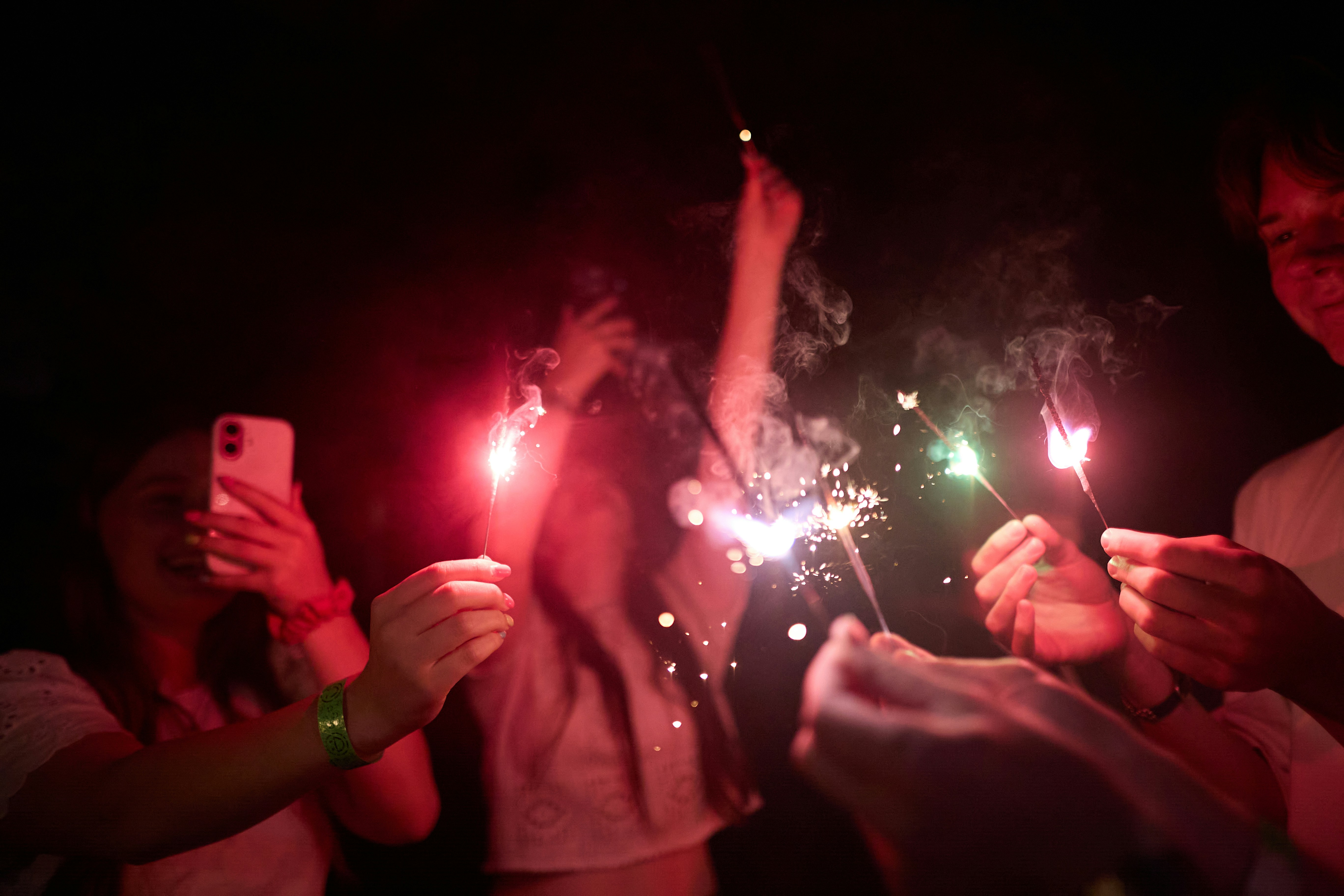 Midnight Spark: Hands and Sparklers in a Flash of Color