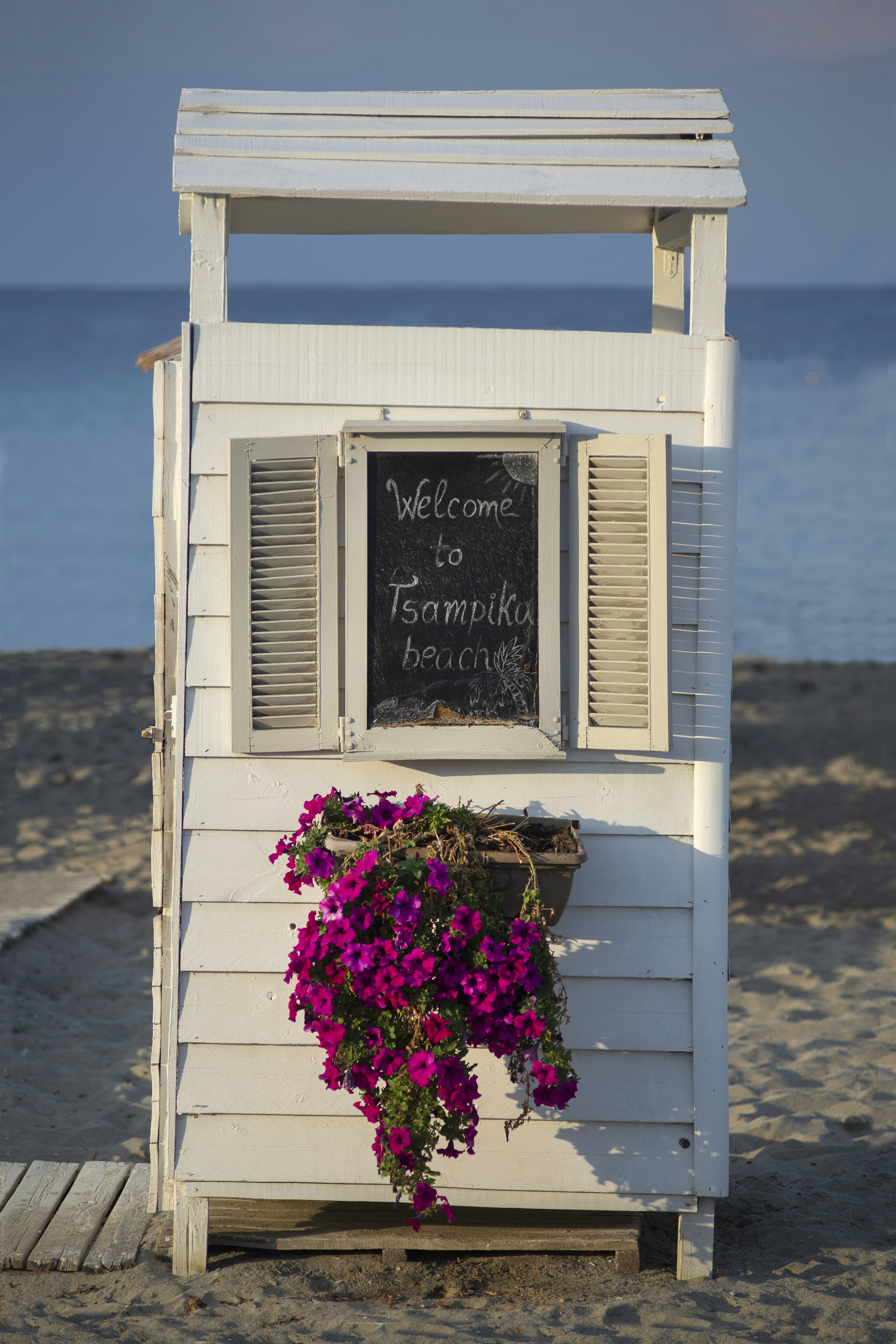 White Lifebuoy Shack by the Sea with Fuchsia Bouquets