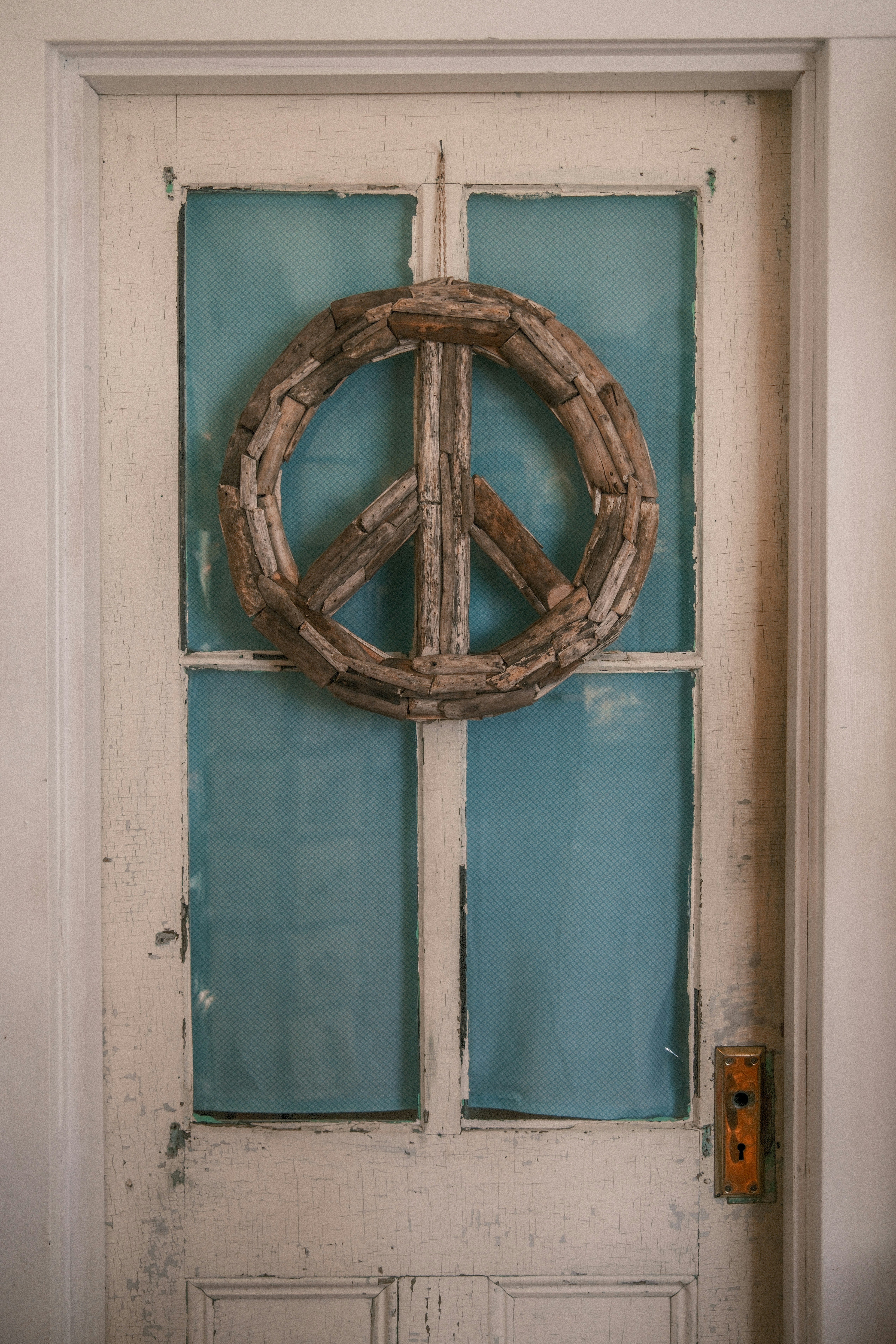 Weathered door with a rustic peace symbol centerpiece