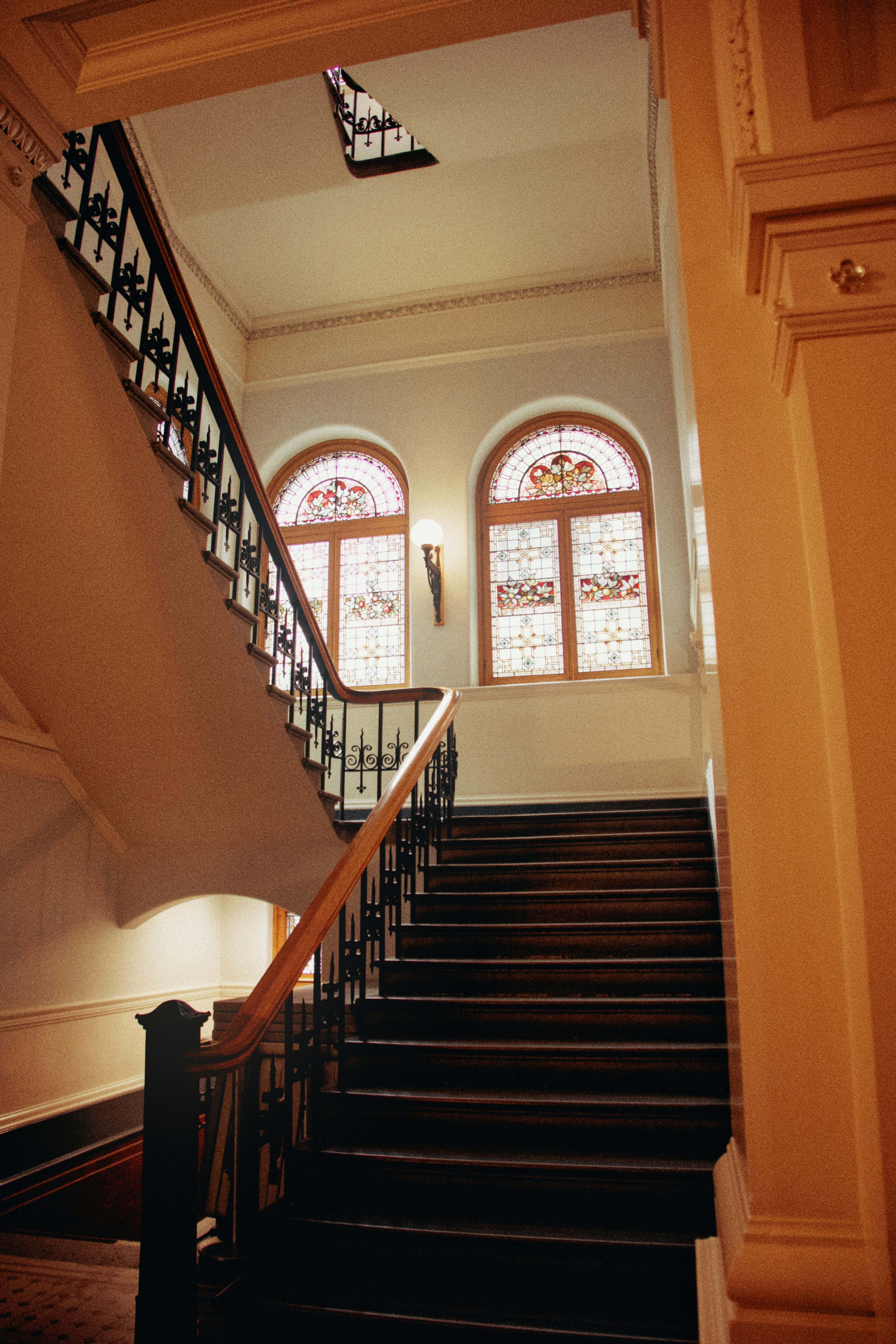 Sunlit Staircase with Stained Glass Echoes