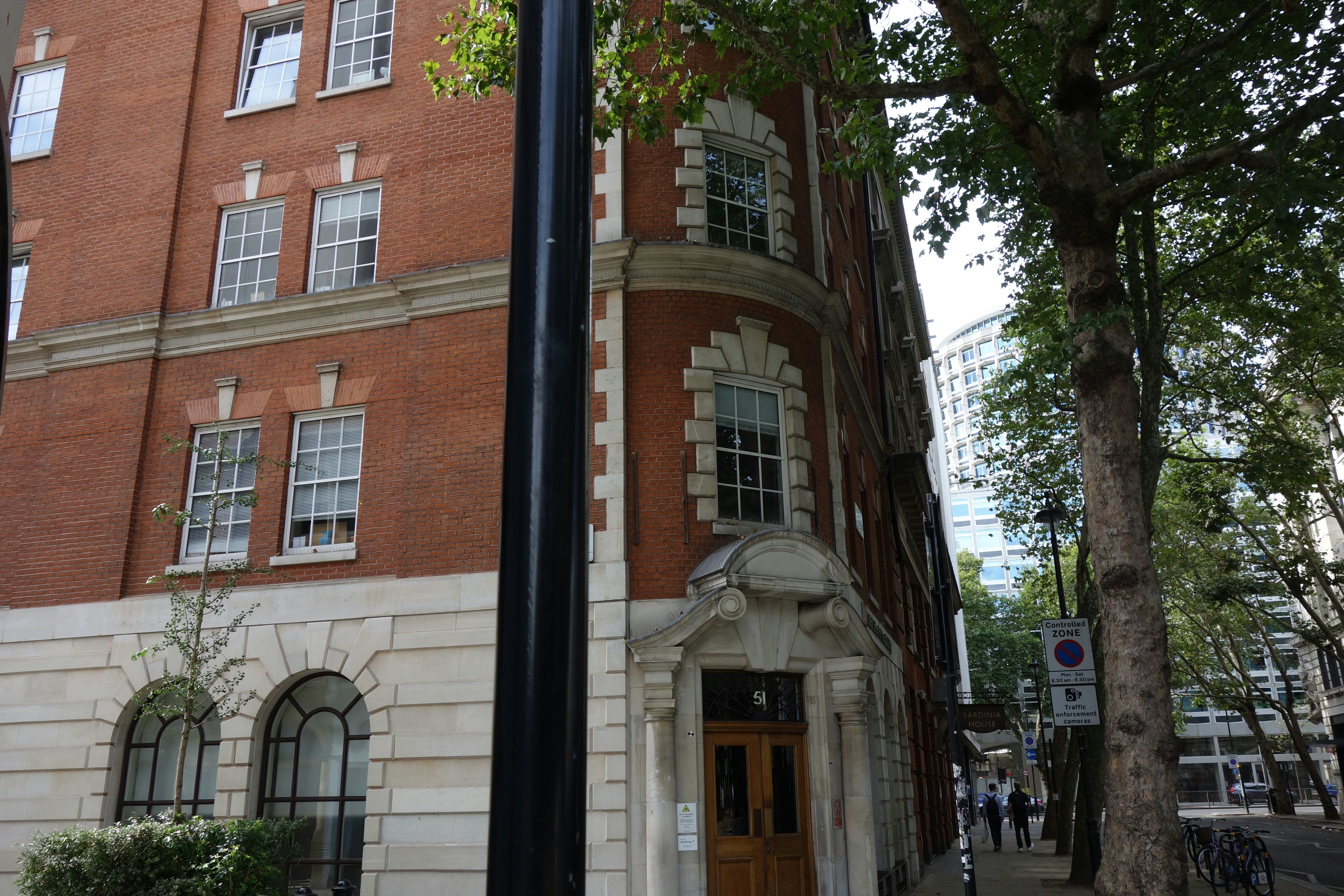 Cornered Architecture: A City Street Gate Framed by a Historic Red Brick Facade