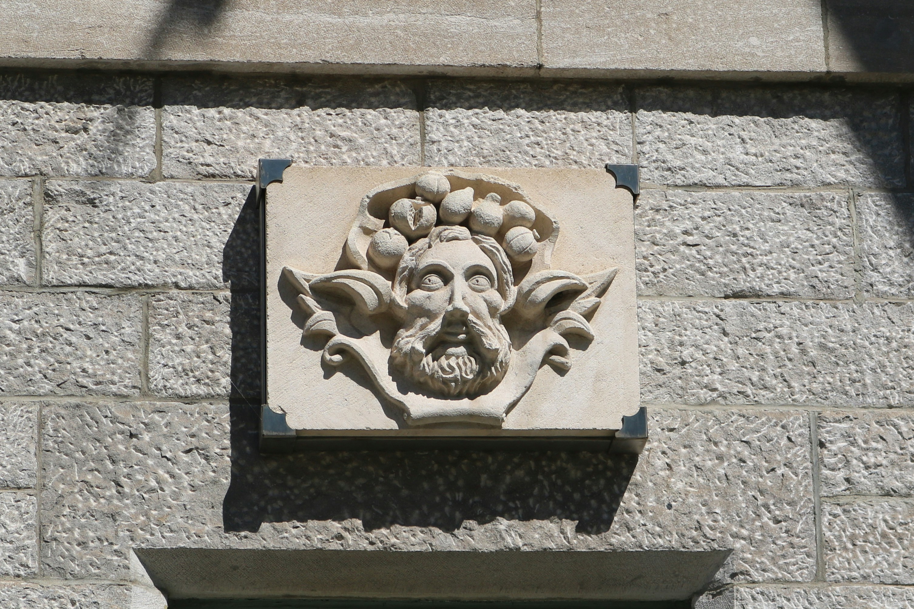 Stone Crest: A Carved Bearded Figure Guarding the Doorway