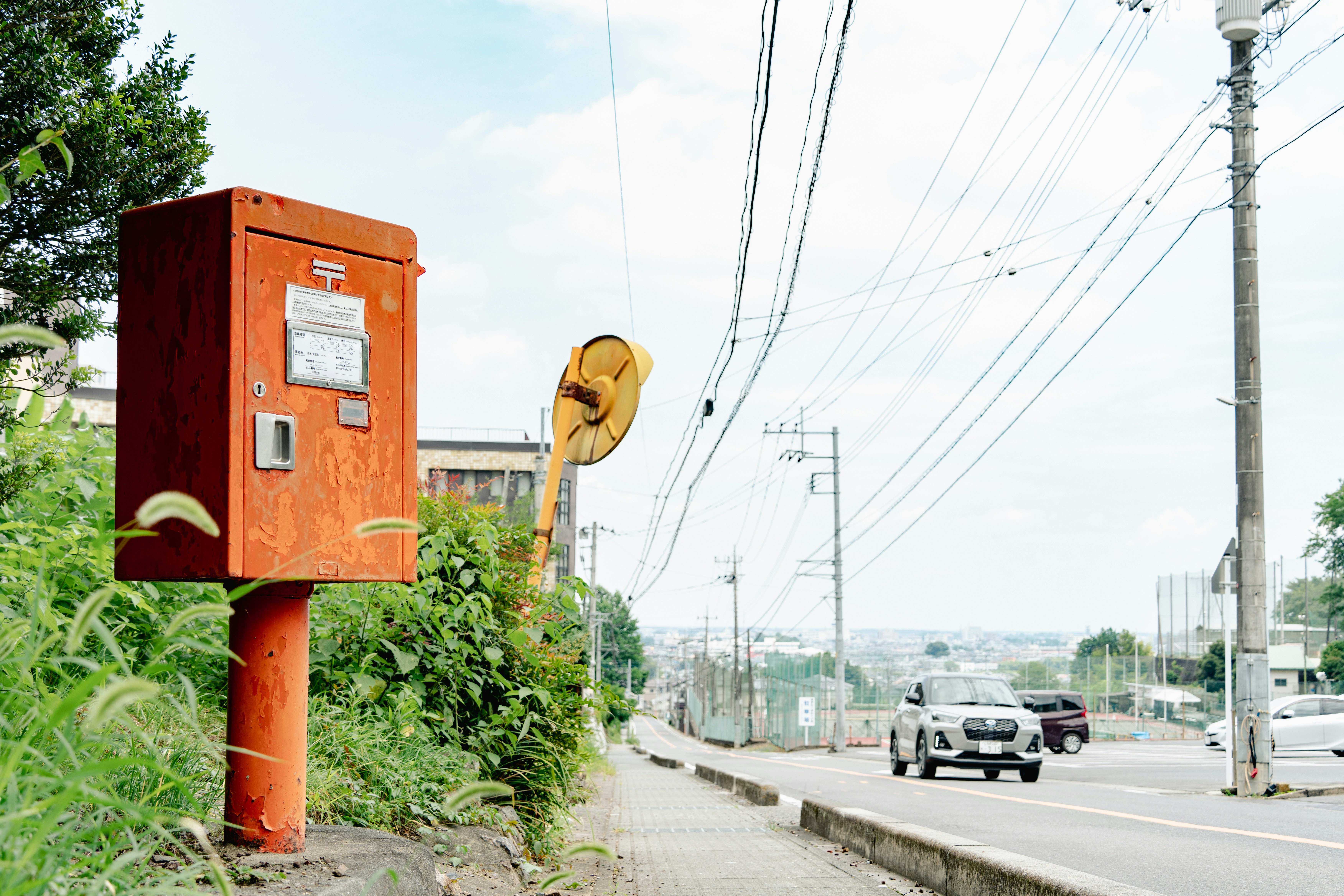 Red Post Box at the Edge of a Quiet Urban Road