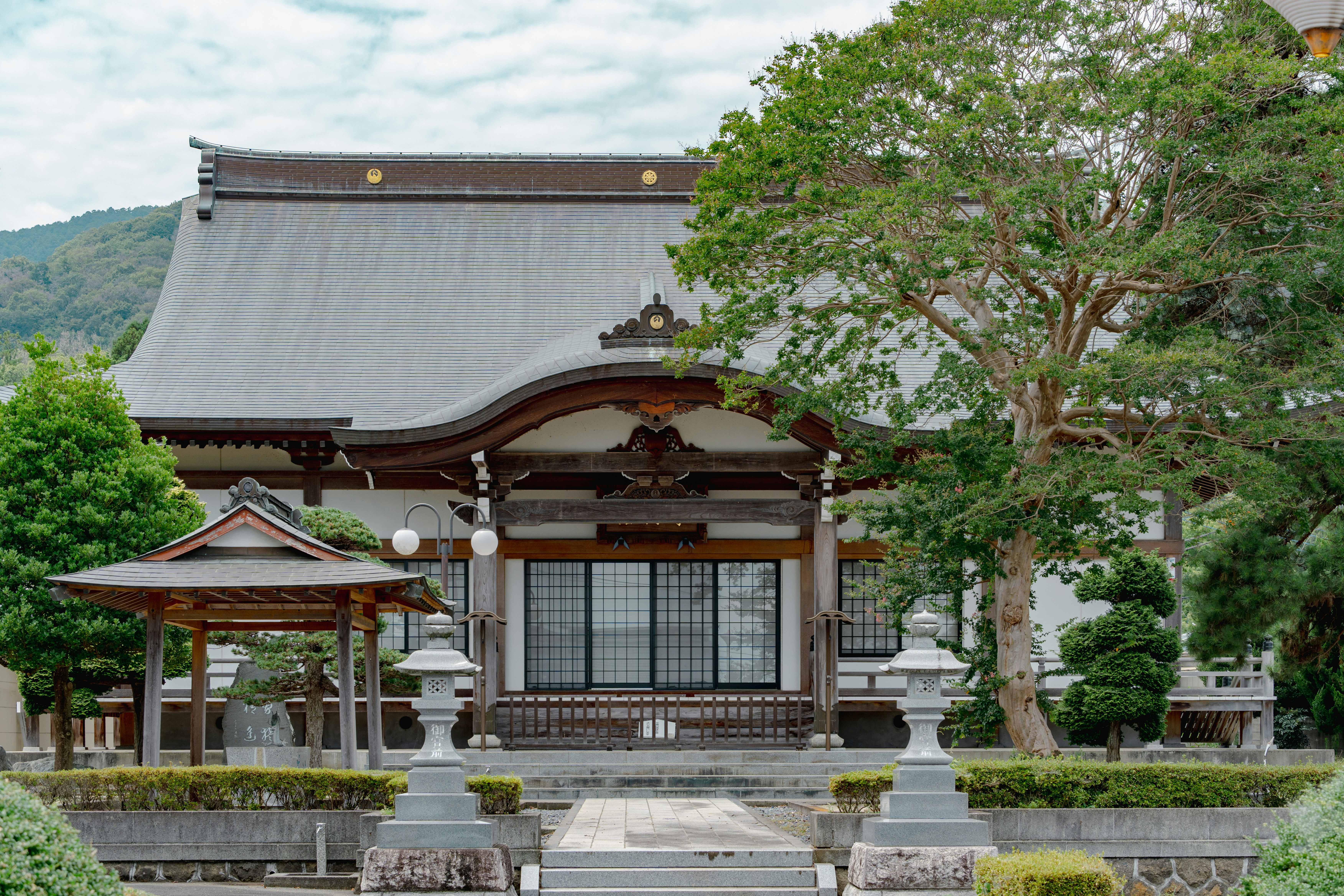 Temple Courtyard with Traditional Roofline and Stone Lanterns
