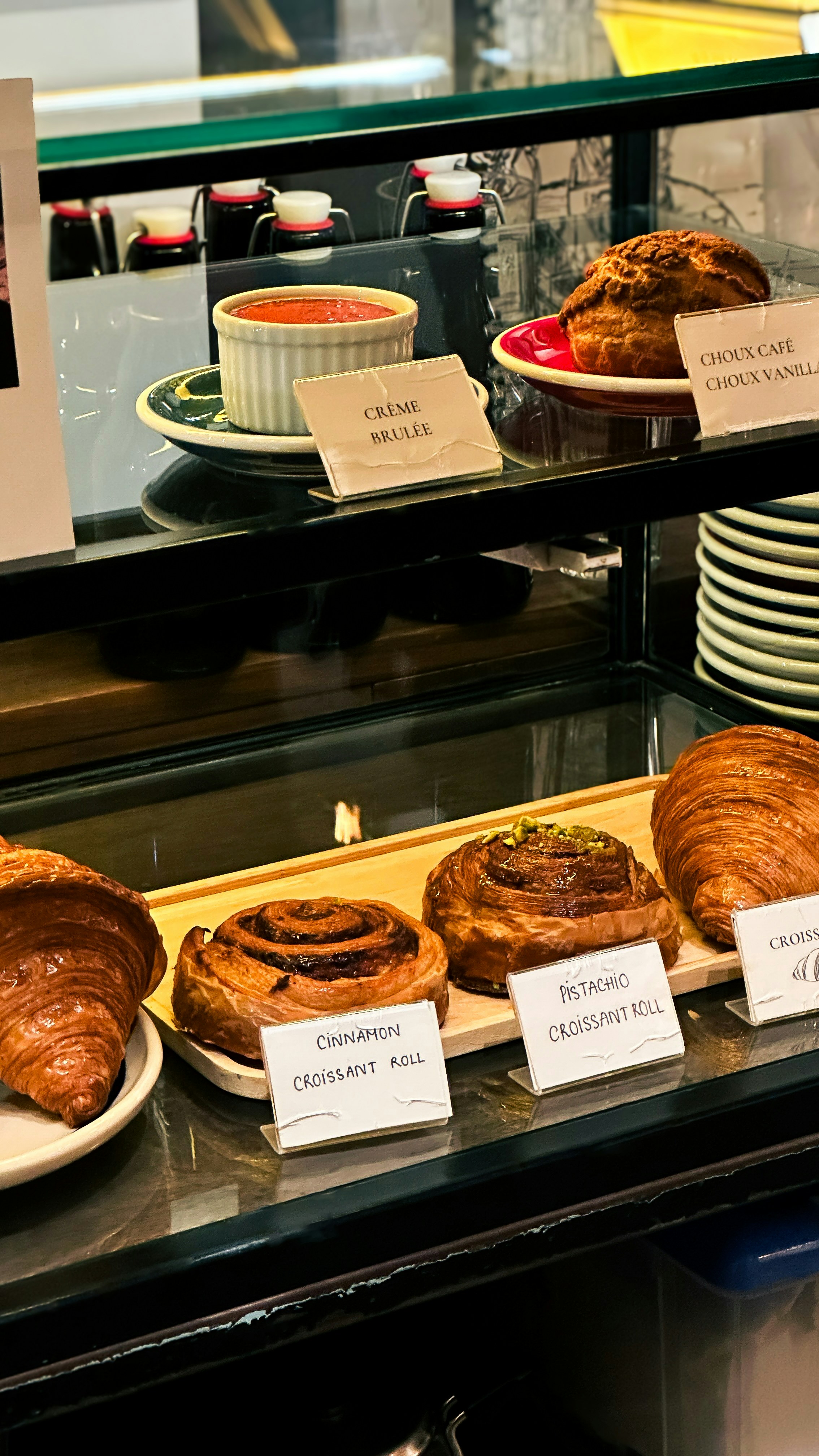 Pastry Display: Cinnamon Swirls and Pistachio Croissant in a Café Case