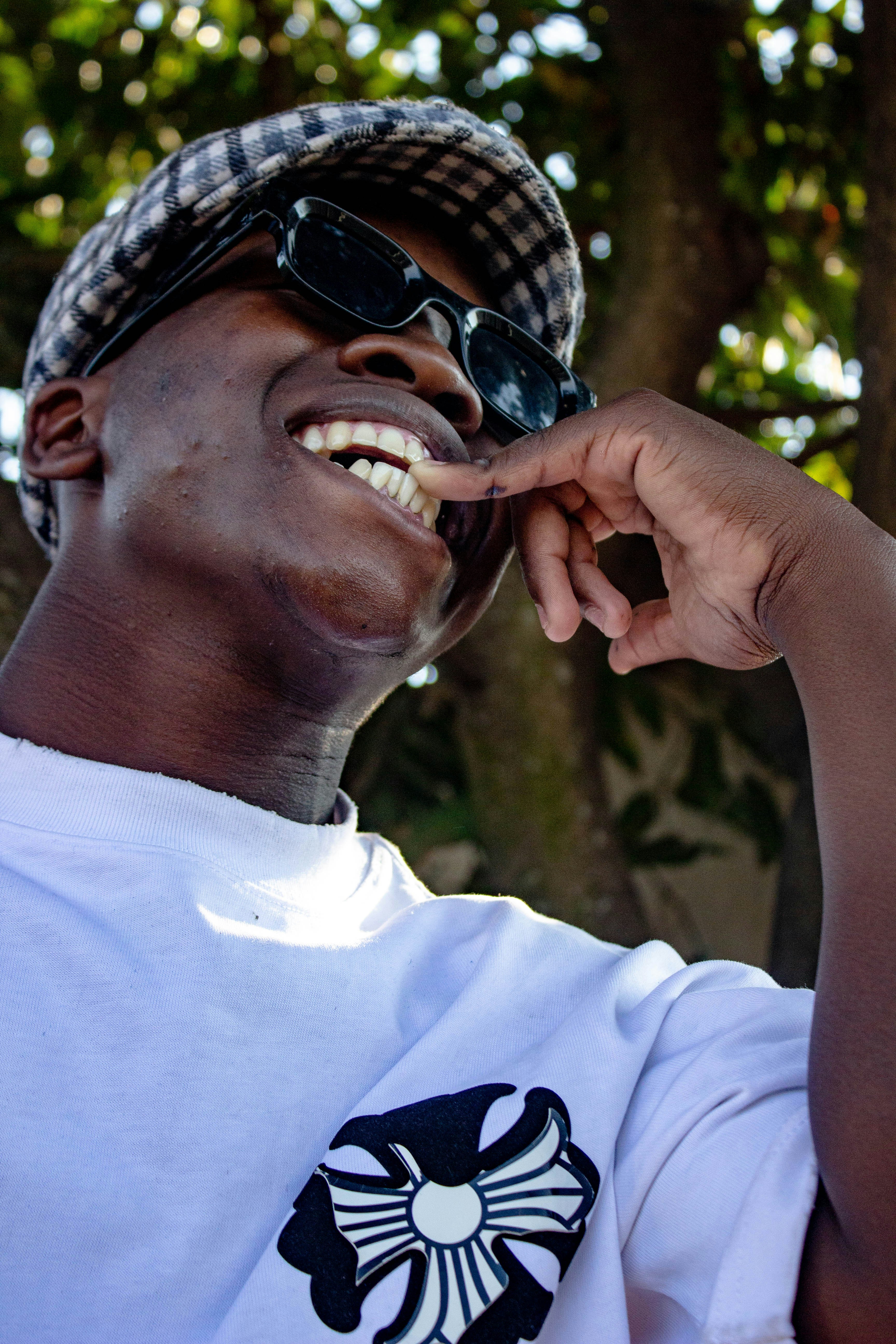 Smile in Shade: A Lively Portrait with Sunglasses and Cap