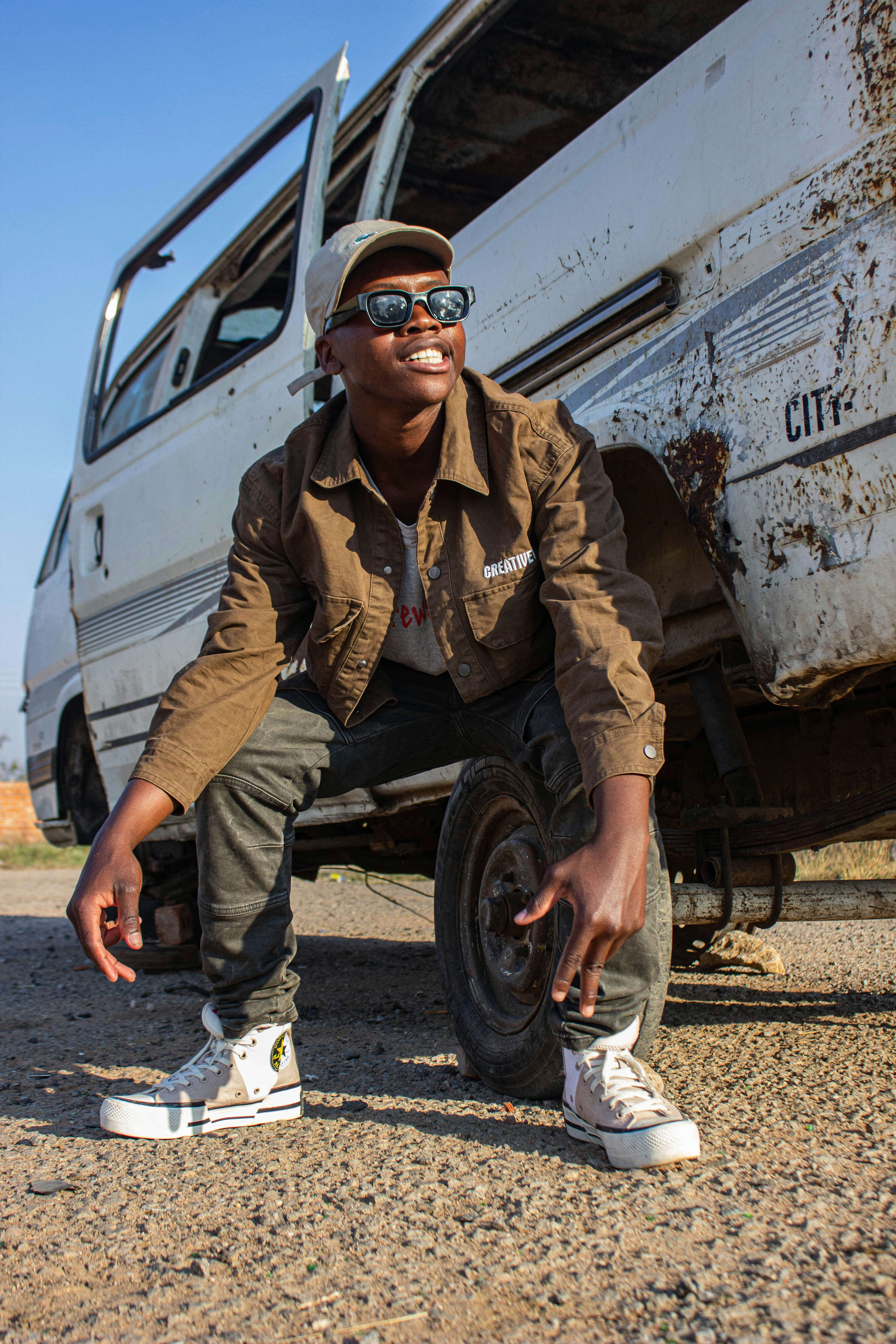 Youthful Explorer by a Weathered Van Under Bright Desert Sun