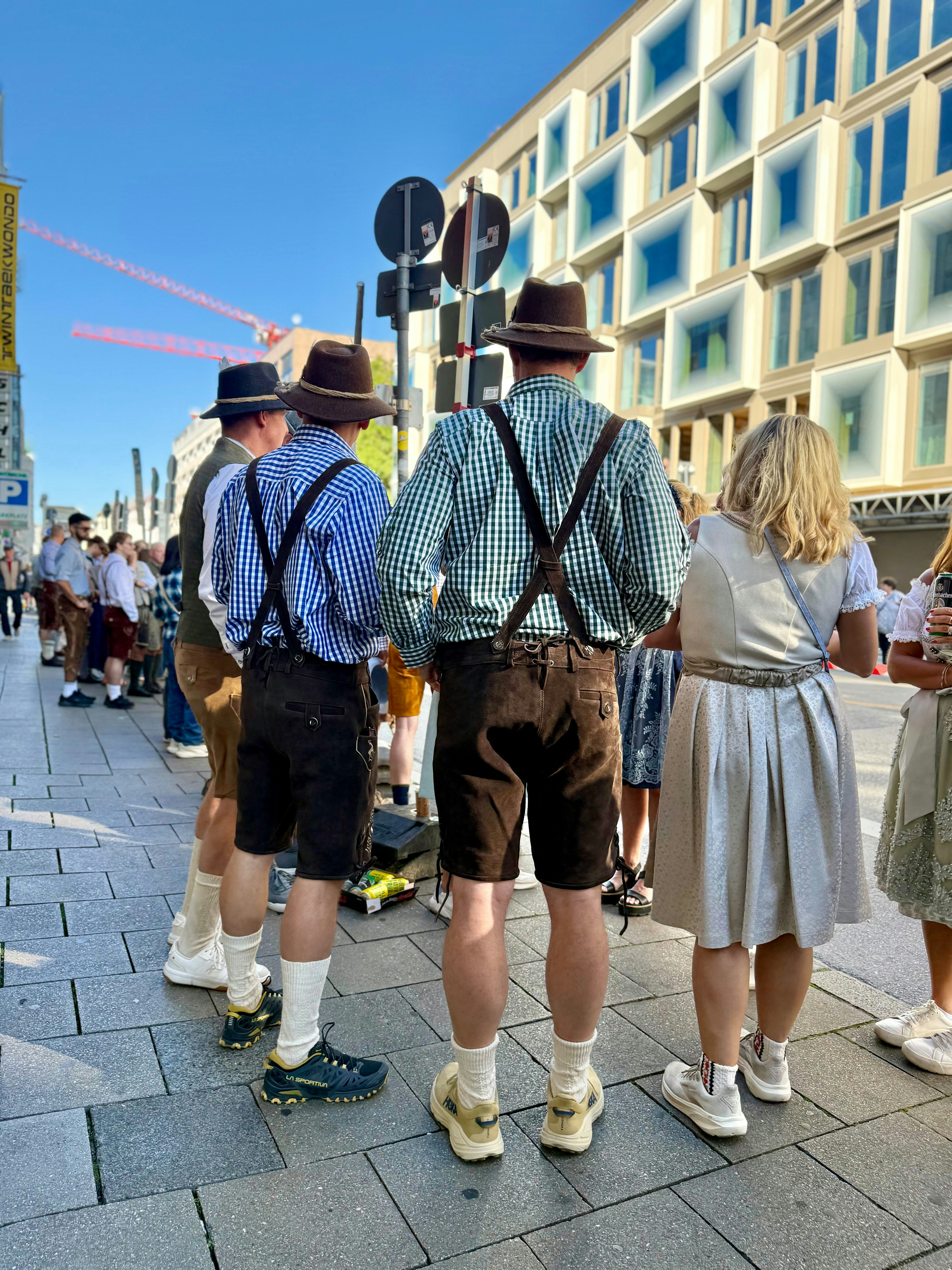 The Line of Lederhosen: A Traditional Gatekeeper Assembly on a Modern City Street