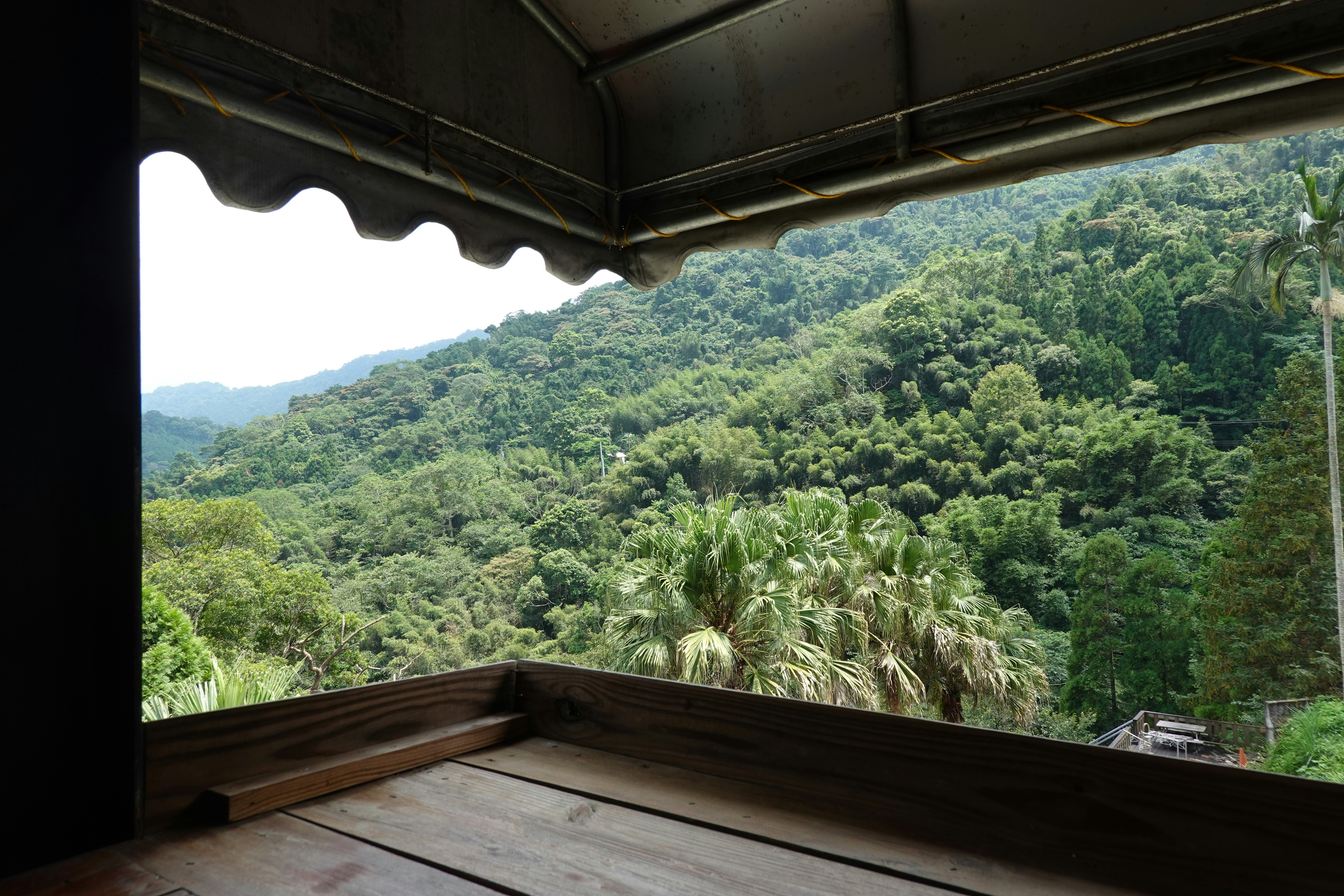 Horizon Gap: A Shaded Terrace Framing Lush Green Peaks