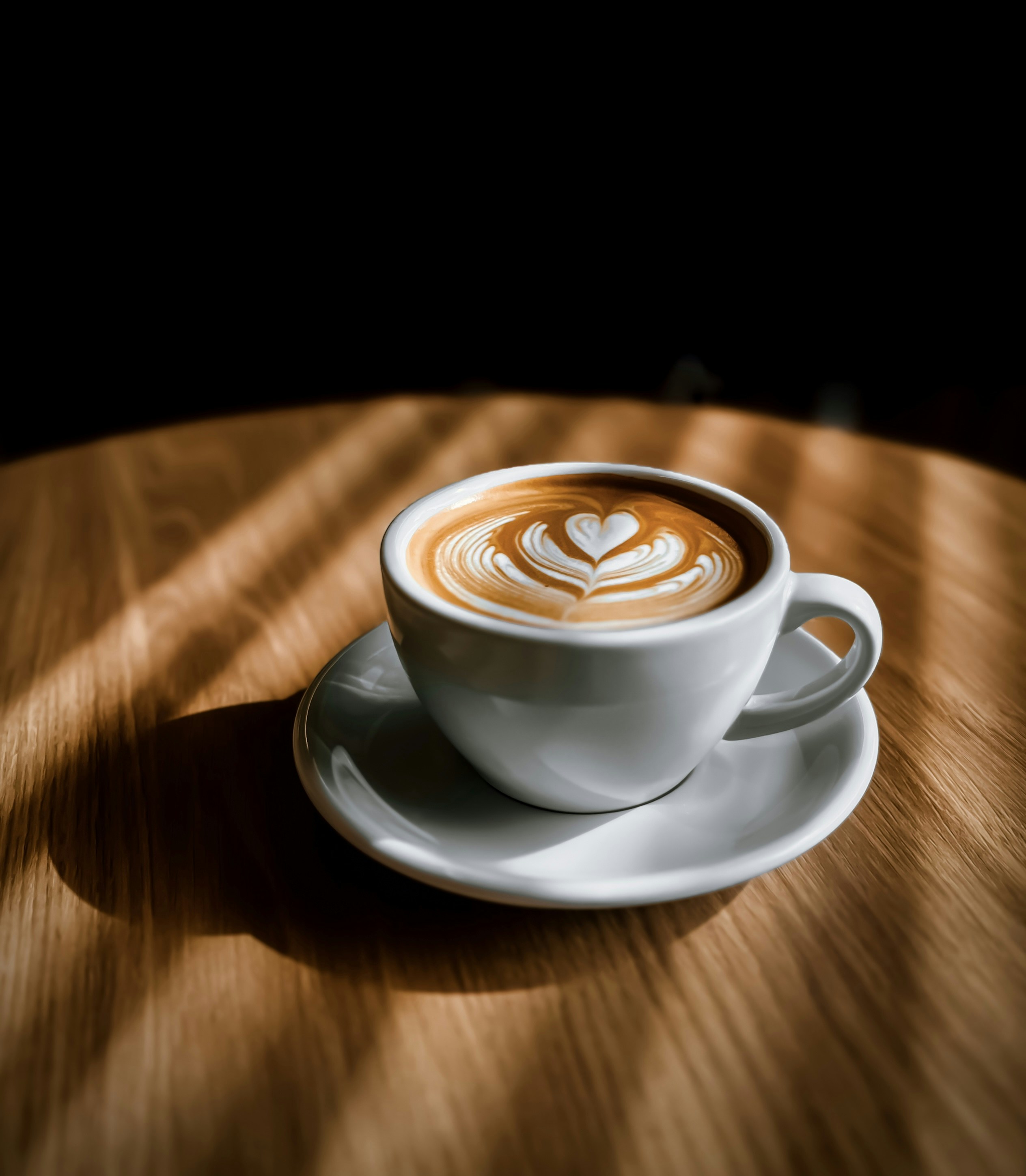 Ceremonial Cup: Heart Latte on a Sunlit Wooden Table