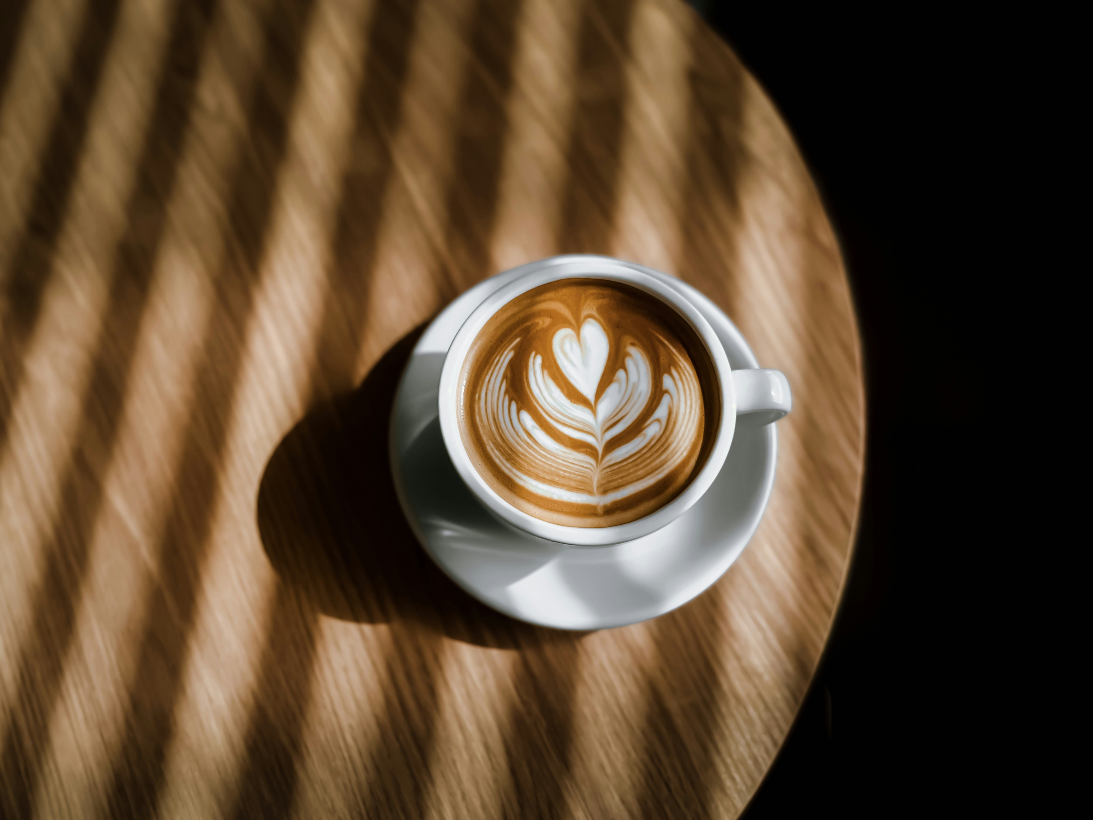 Heart of Espresso: A Cappuccino Rosetta on a Sunlit Table