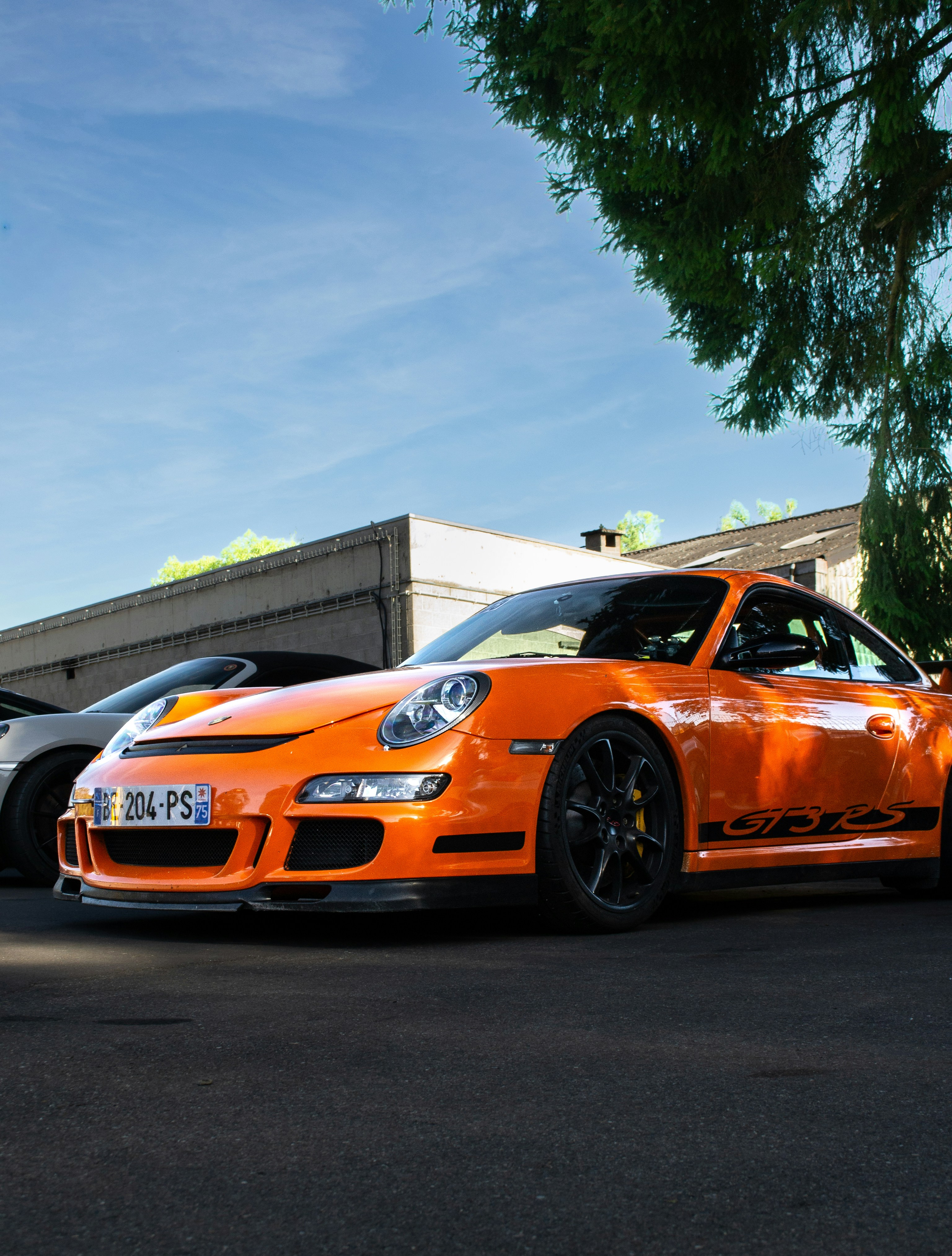 Orange Porsche GT3 RS Anchored by Shadow and Sky