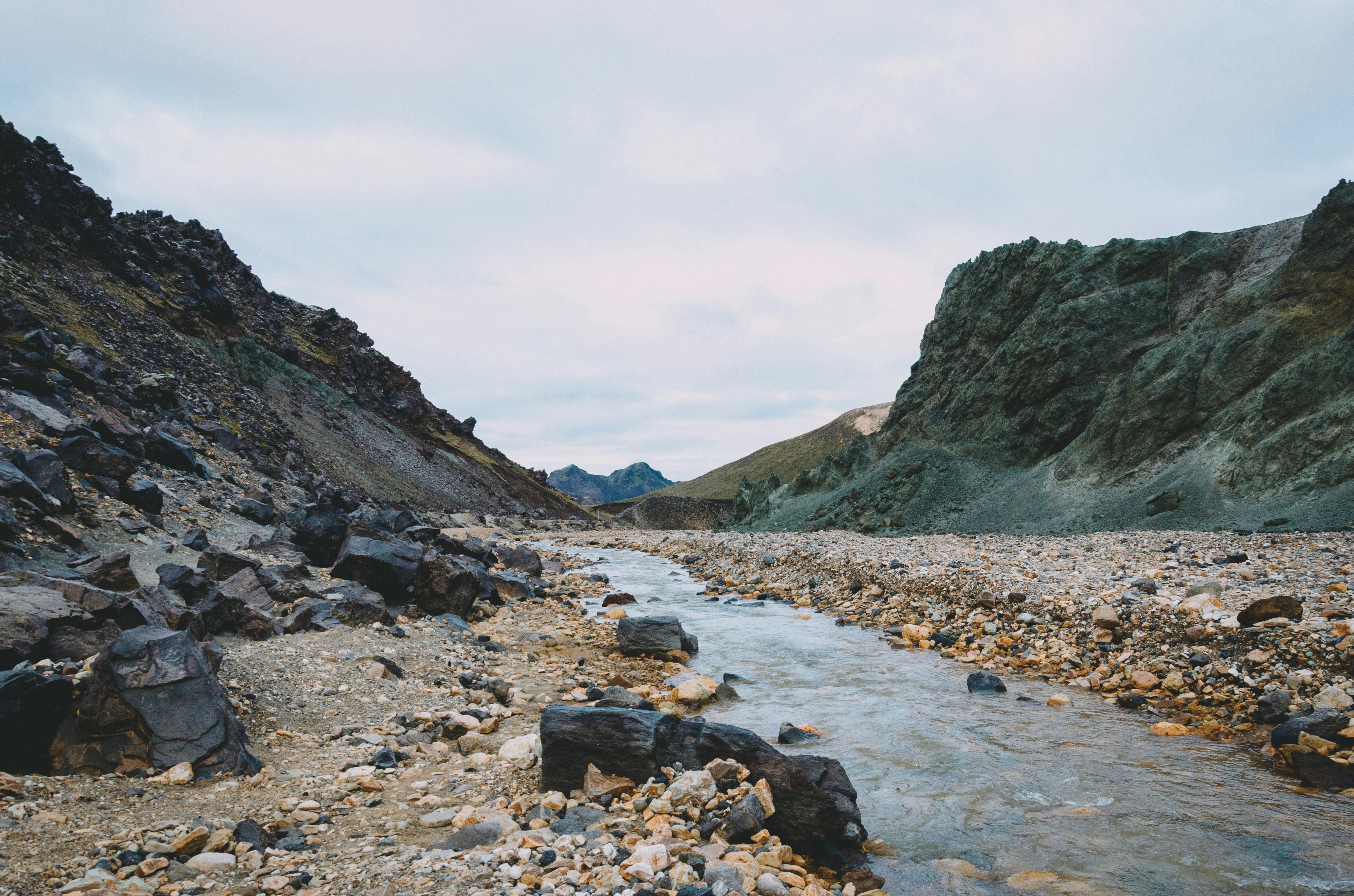 Rugged Gorge: A Shallow River Winding Between Eroded Peaks