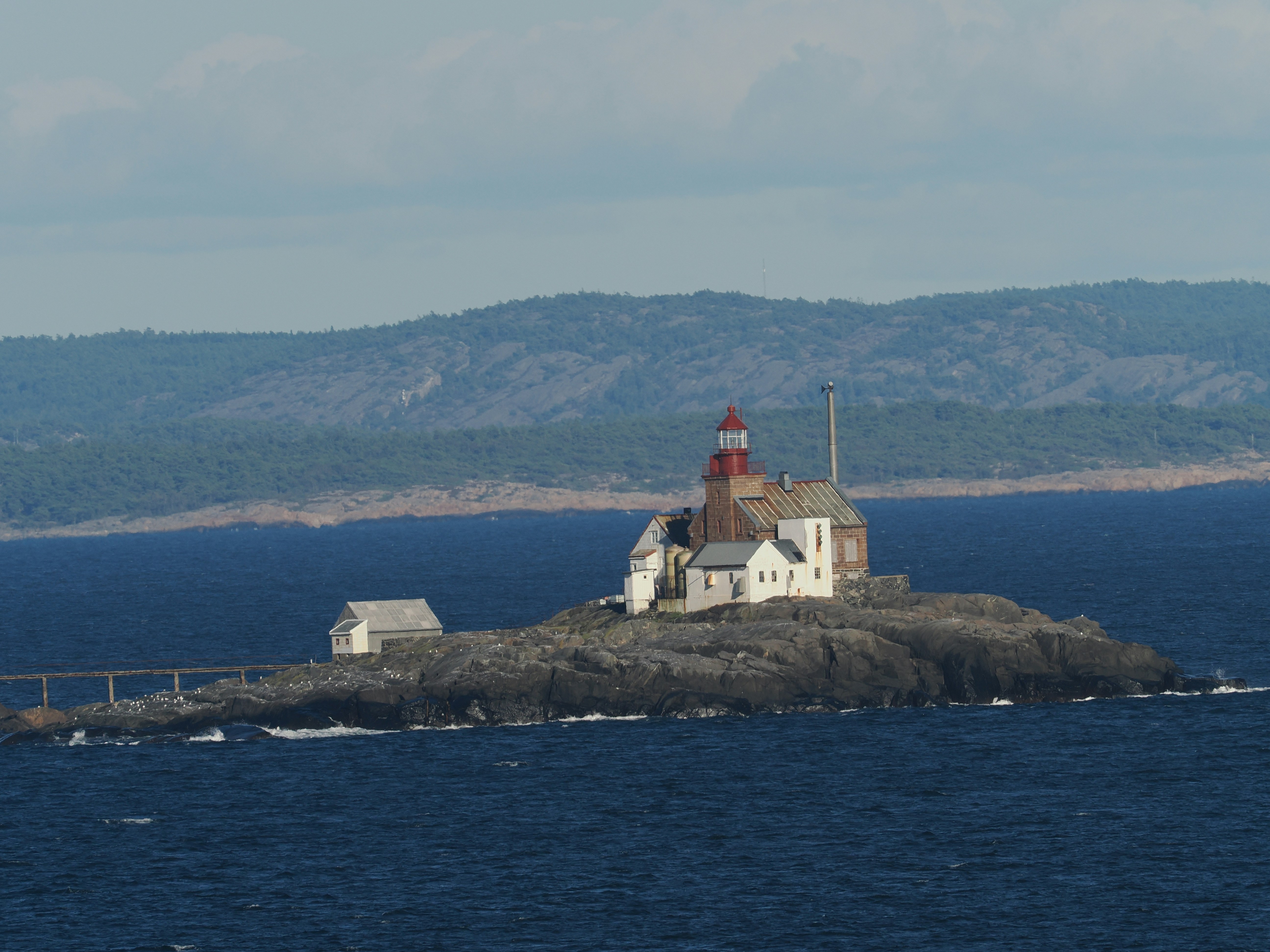 Lighthouse Haven: A Quiet Rock Island with White Buildings and Red Roof