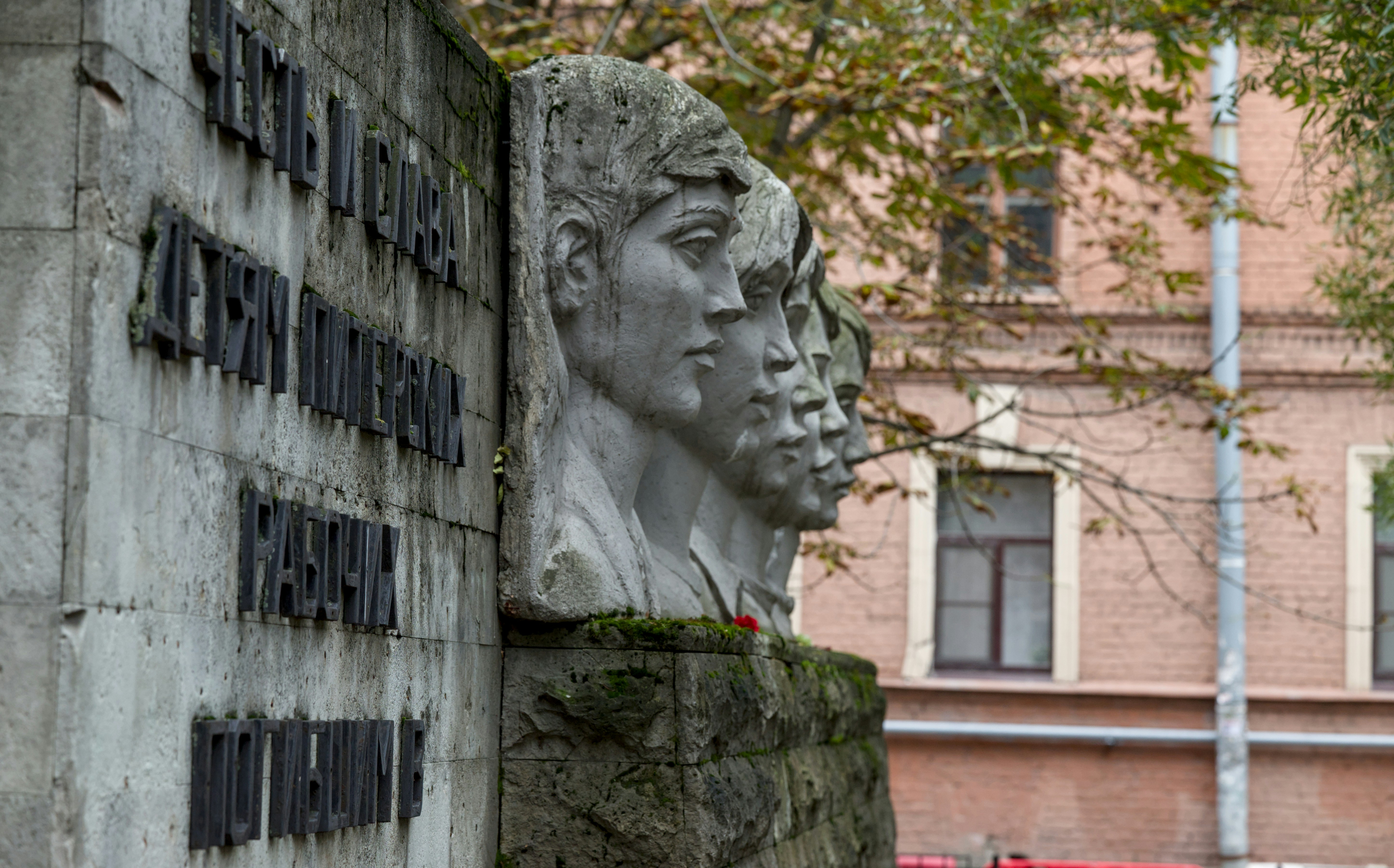 Stone Faces in Shadow: A Quiet Memorial by the Wall