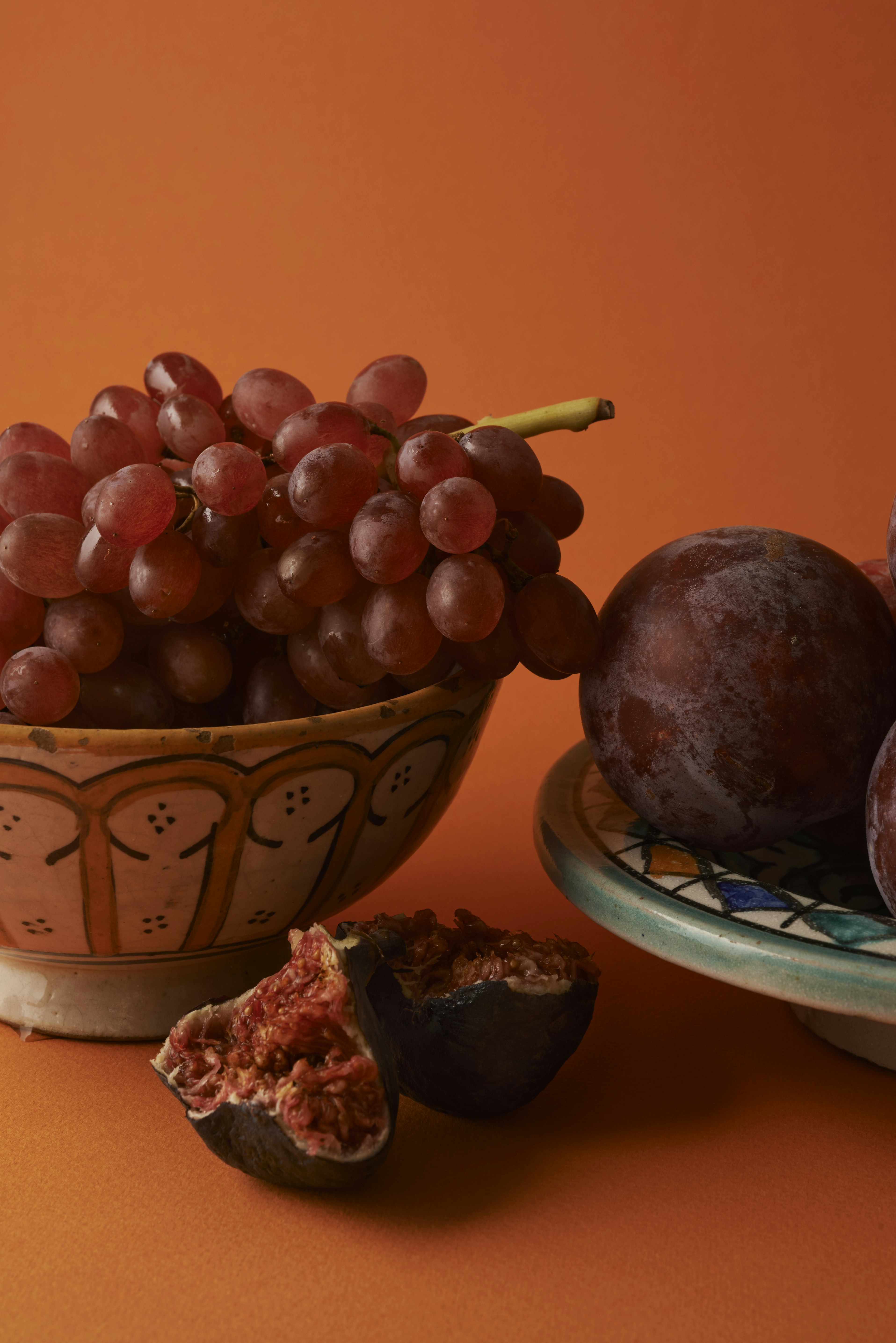 Crimson Bounty: Grapes and Nectarine in Warm Amber