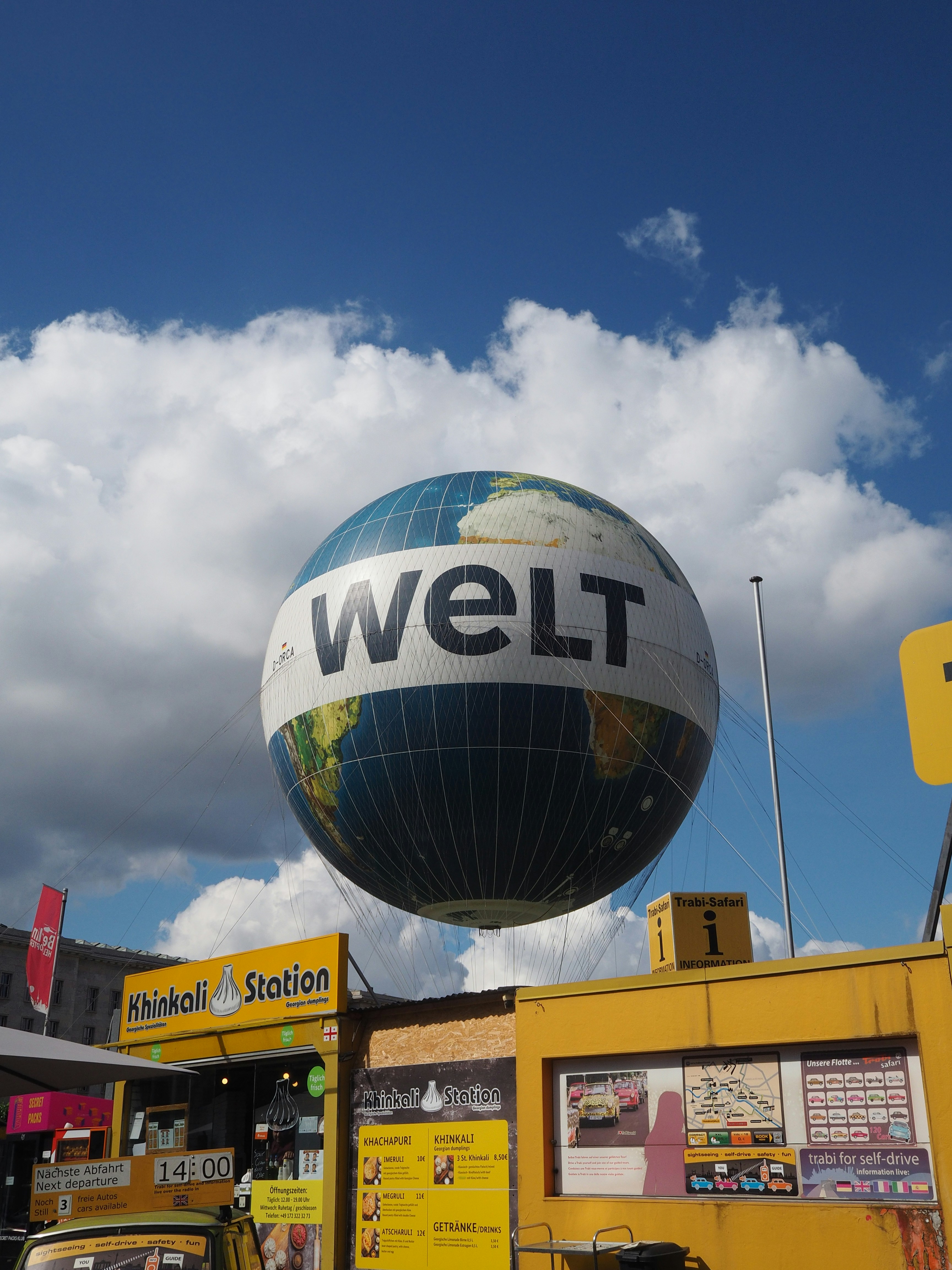 Global Sphere Above Market Stalls: WELT Floating Sign in Yellow Bazaar