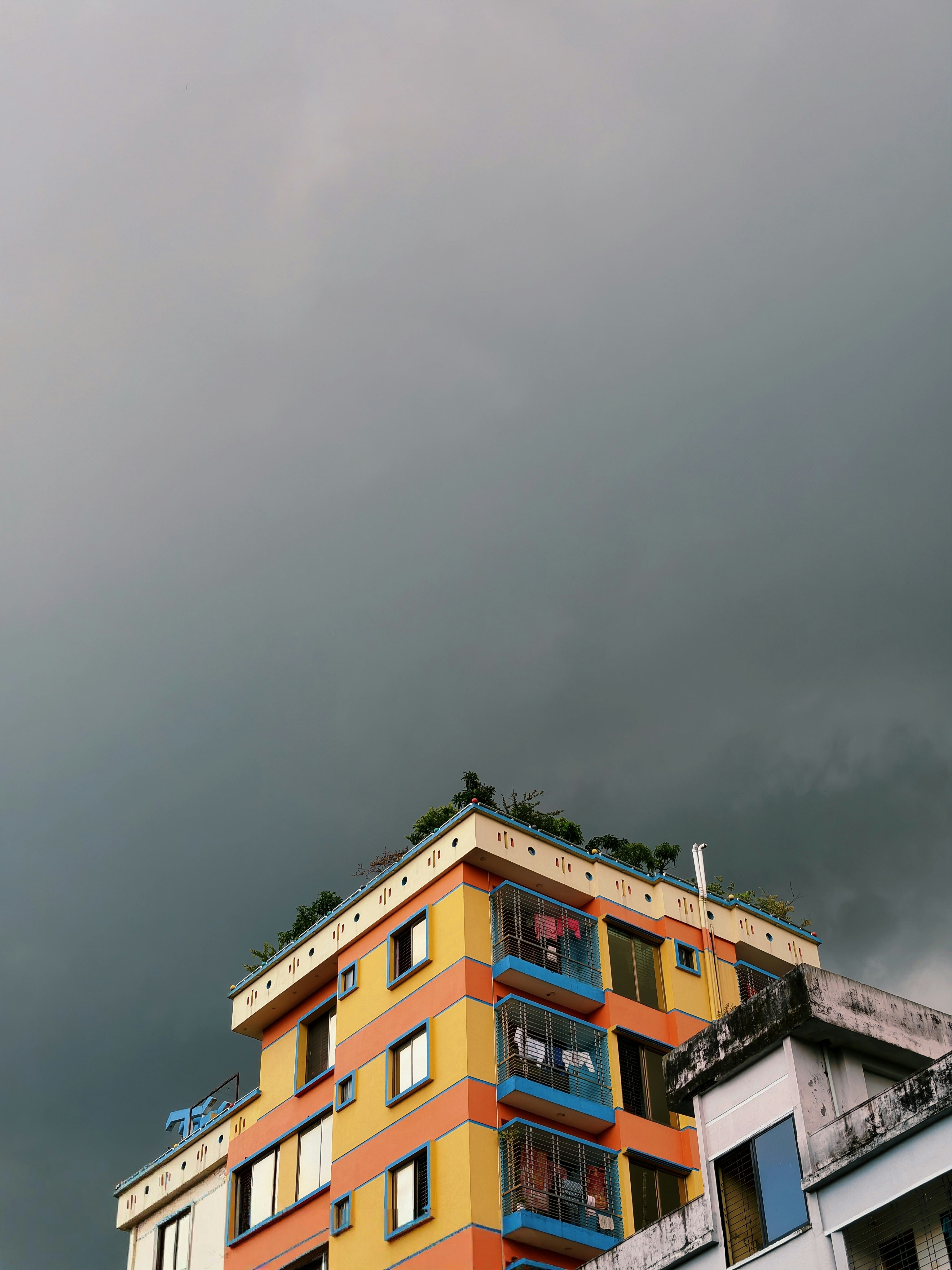 Colorful Apartment Stack Reaches Toward Stormy Skies