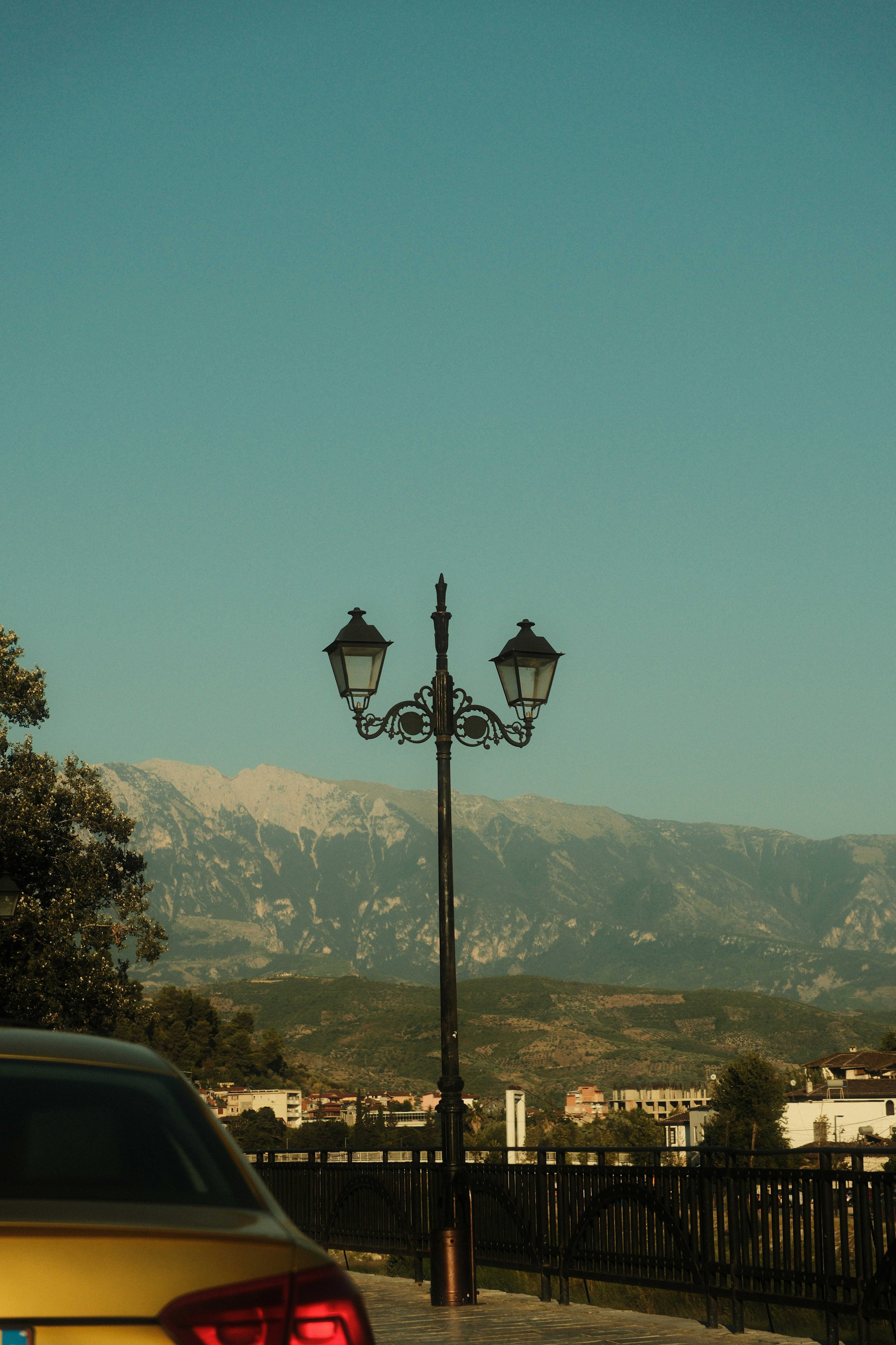 Lamp Post Among Mountains: A Quiet Urban Vista with Classic Streetlamps