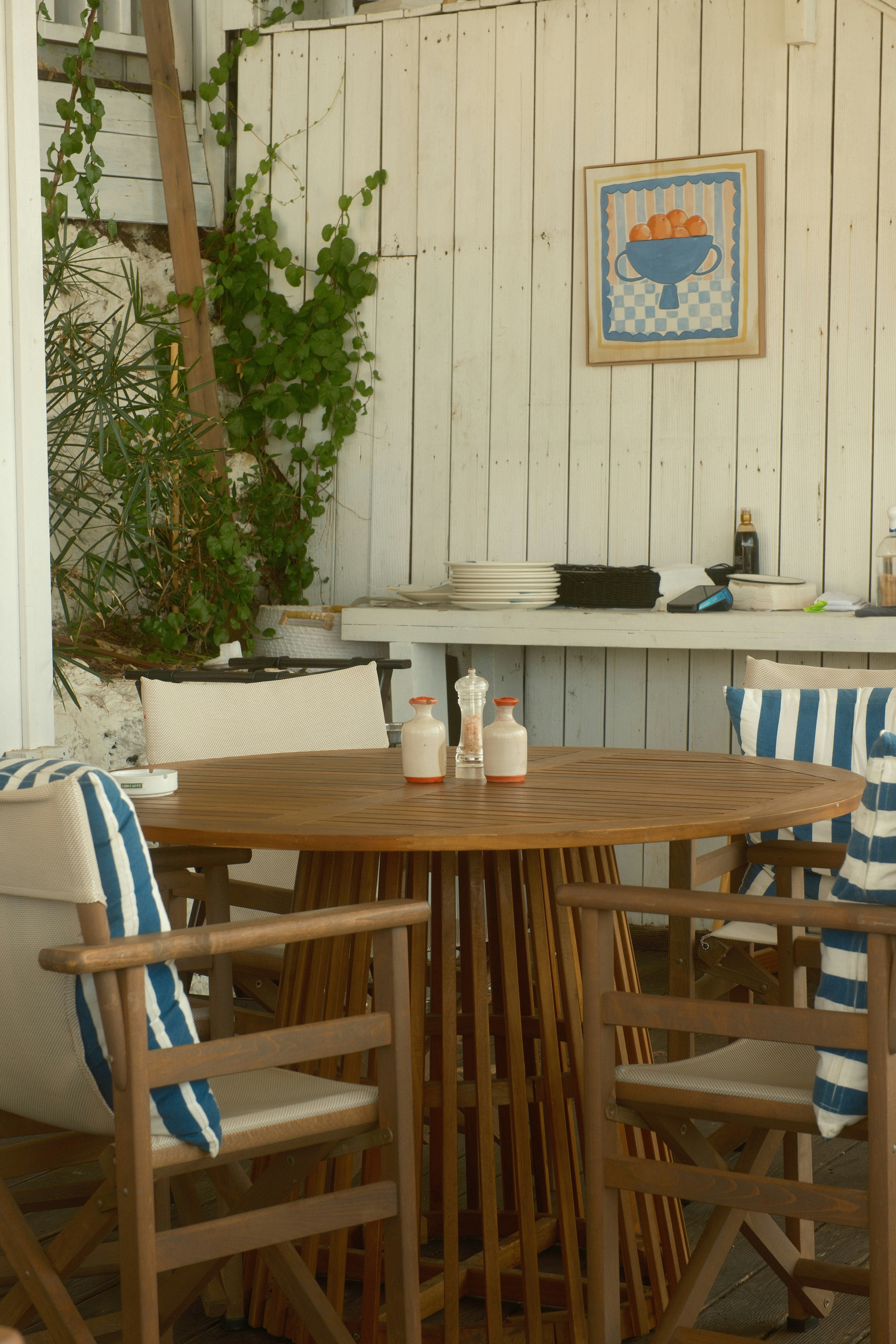 Sunlit Outdoor Bistro: Round Table and Striped Cushions