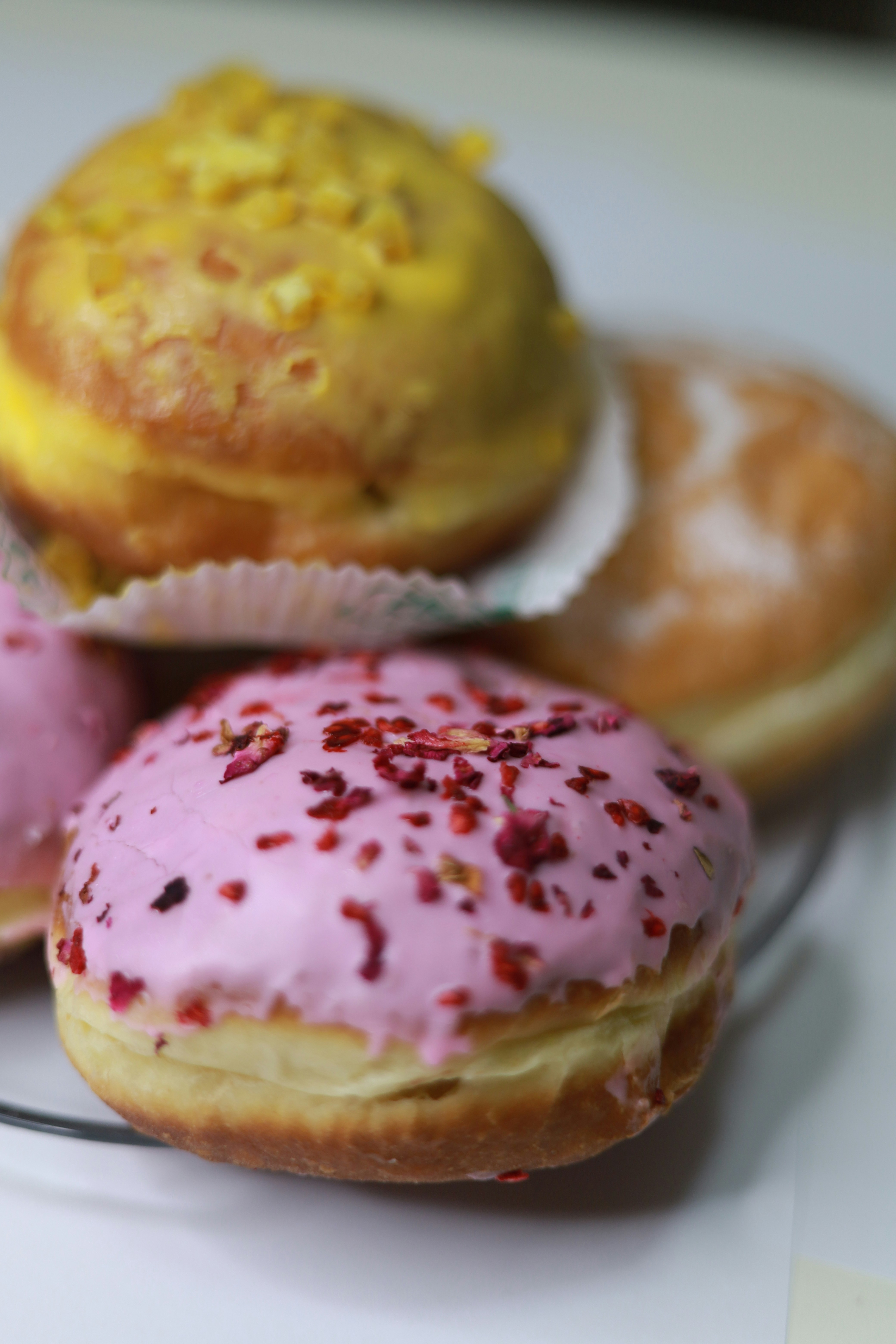 Pink Frosted Donut in Focus: Sugar Crumbs and Soft Glaze