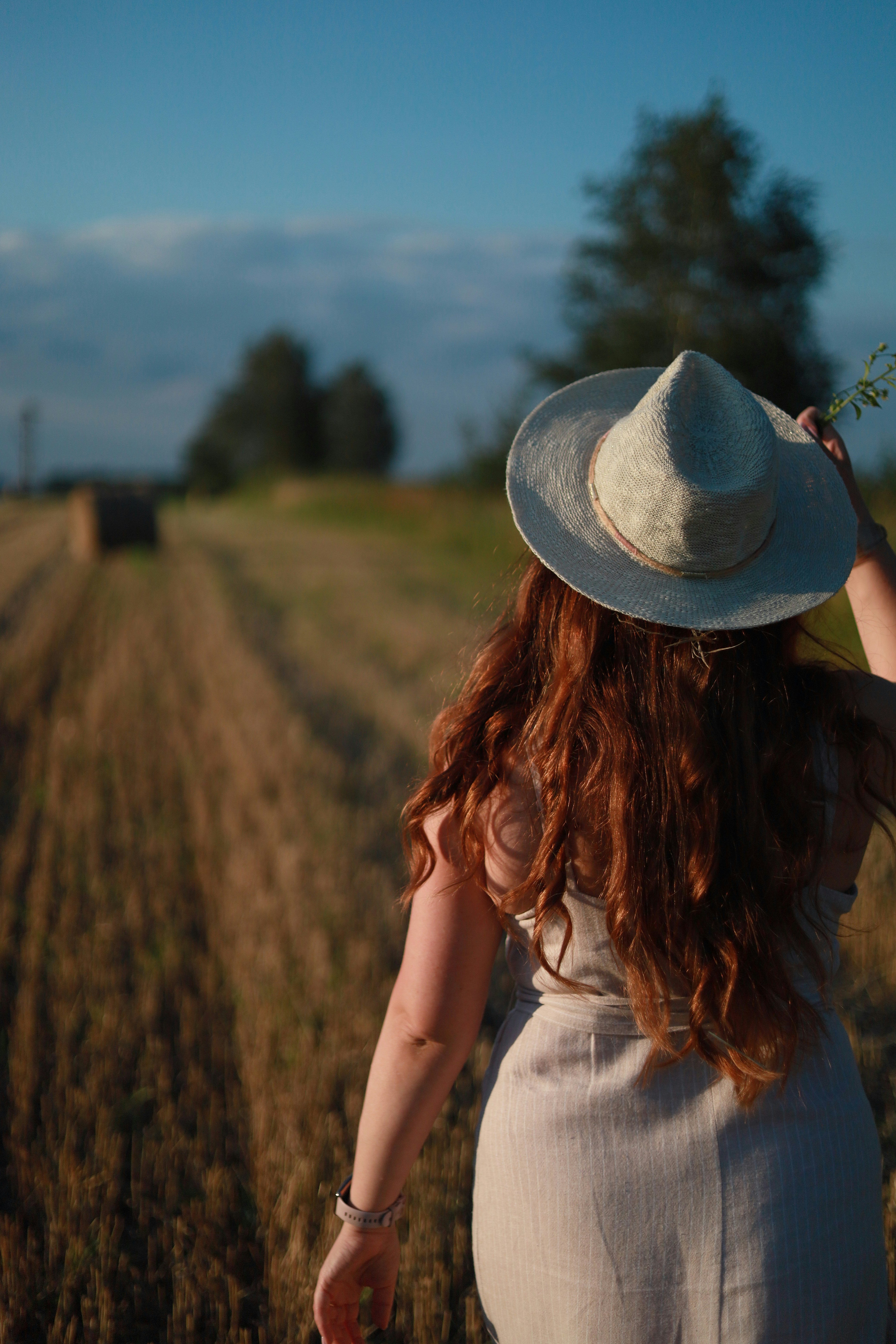 Sunlit Straw: A Woman Walks Toward the Harvest Horizon