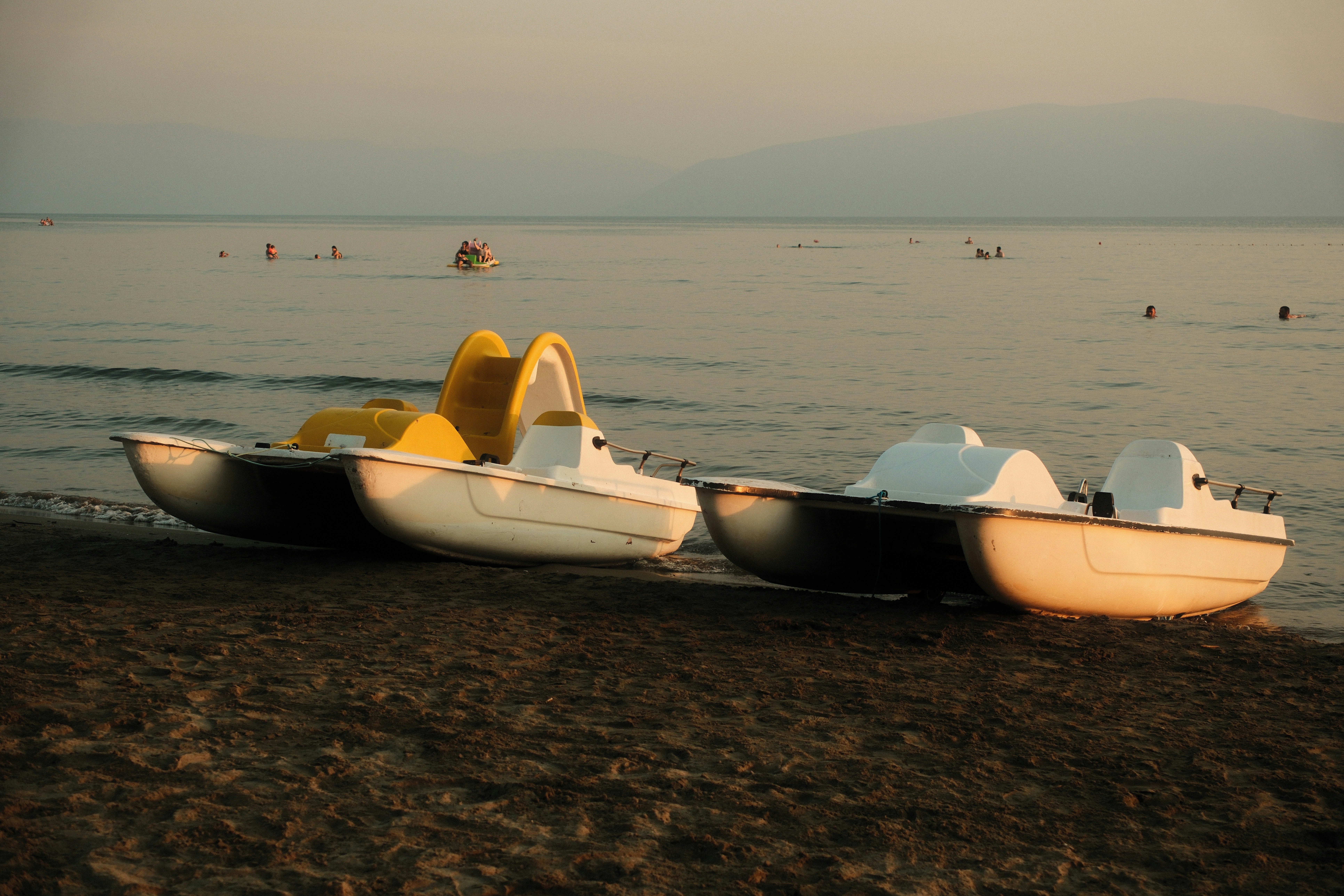 Sunset Harbor: Pedal Boats Rest on Quiet Beach