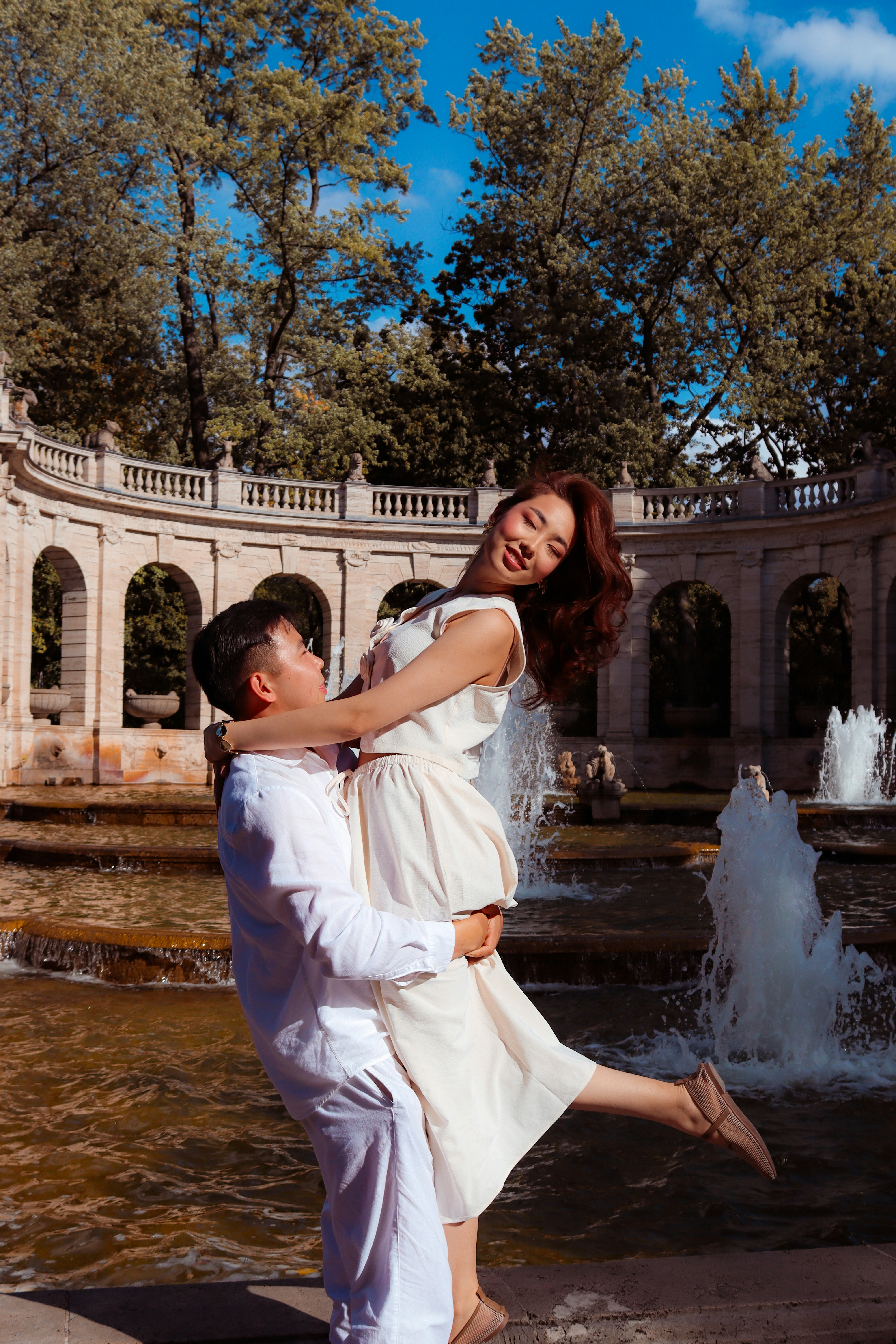 Embrace by the Fountain: A Romantic Lift in White