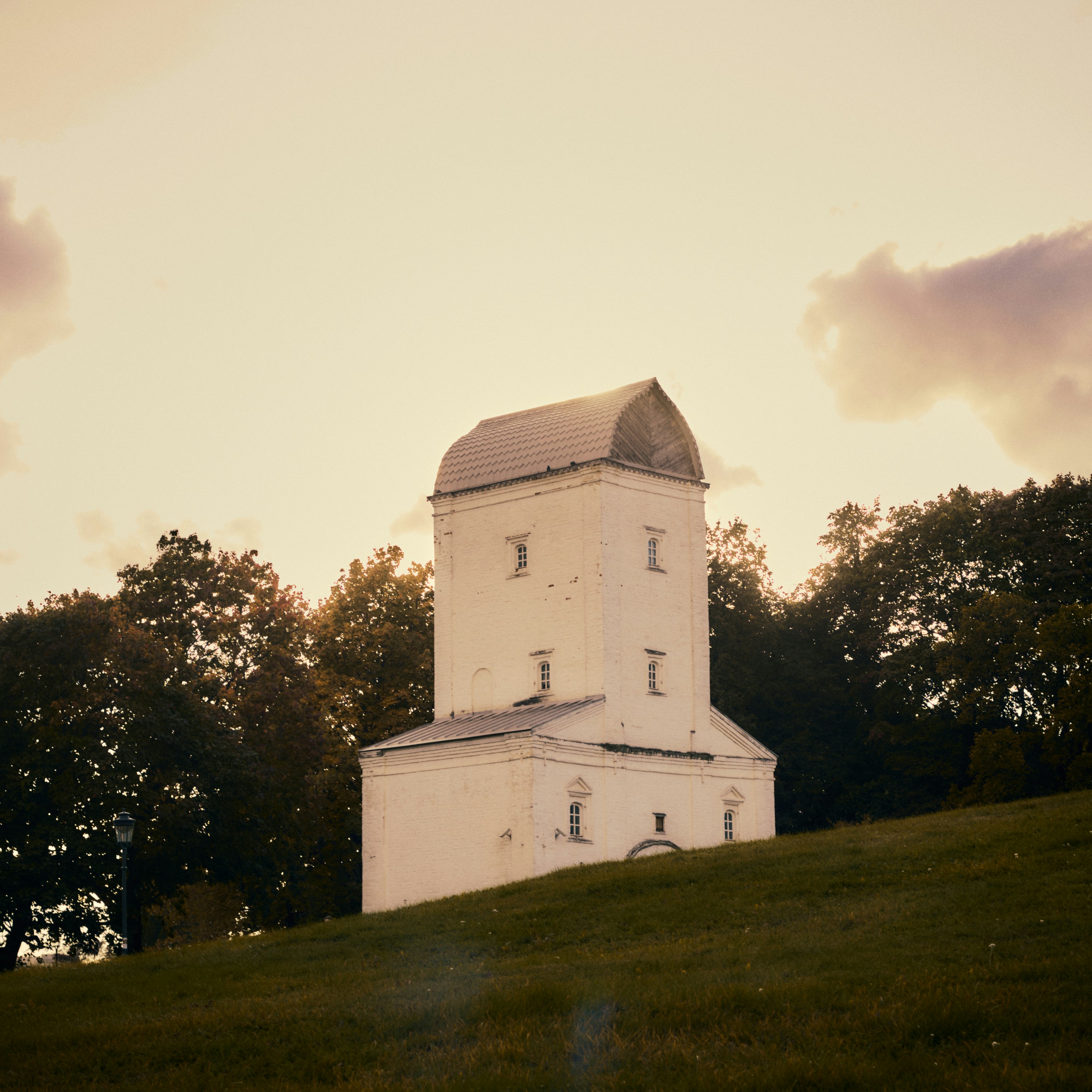 White chapel on a gentle hill under warm autumn light