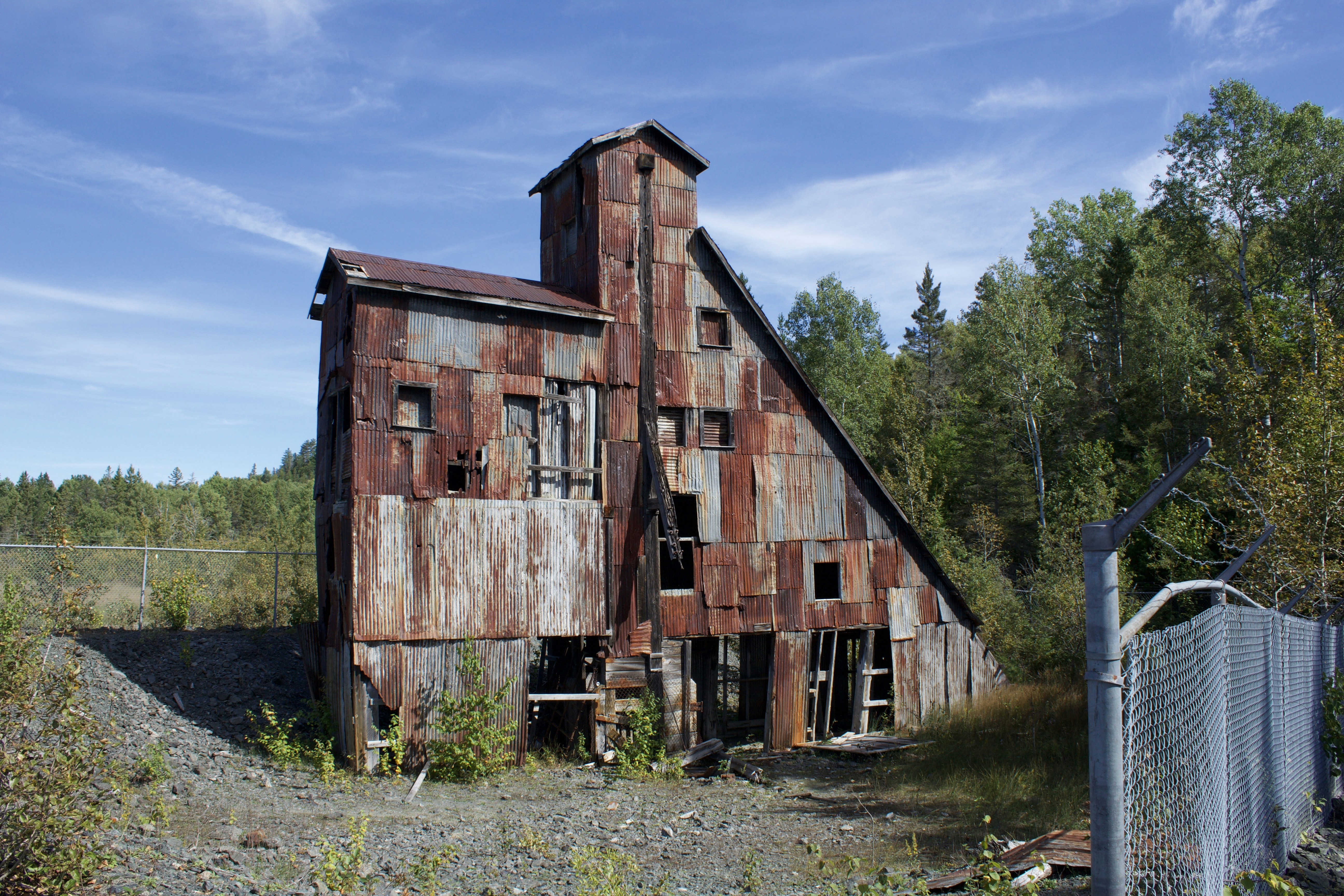 Rusty Triangles: An Abandoned Mill Stand Firm Against the Pines