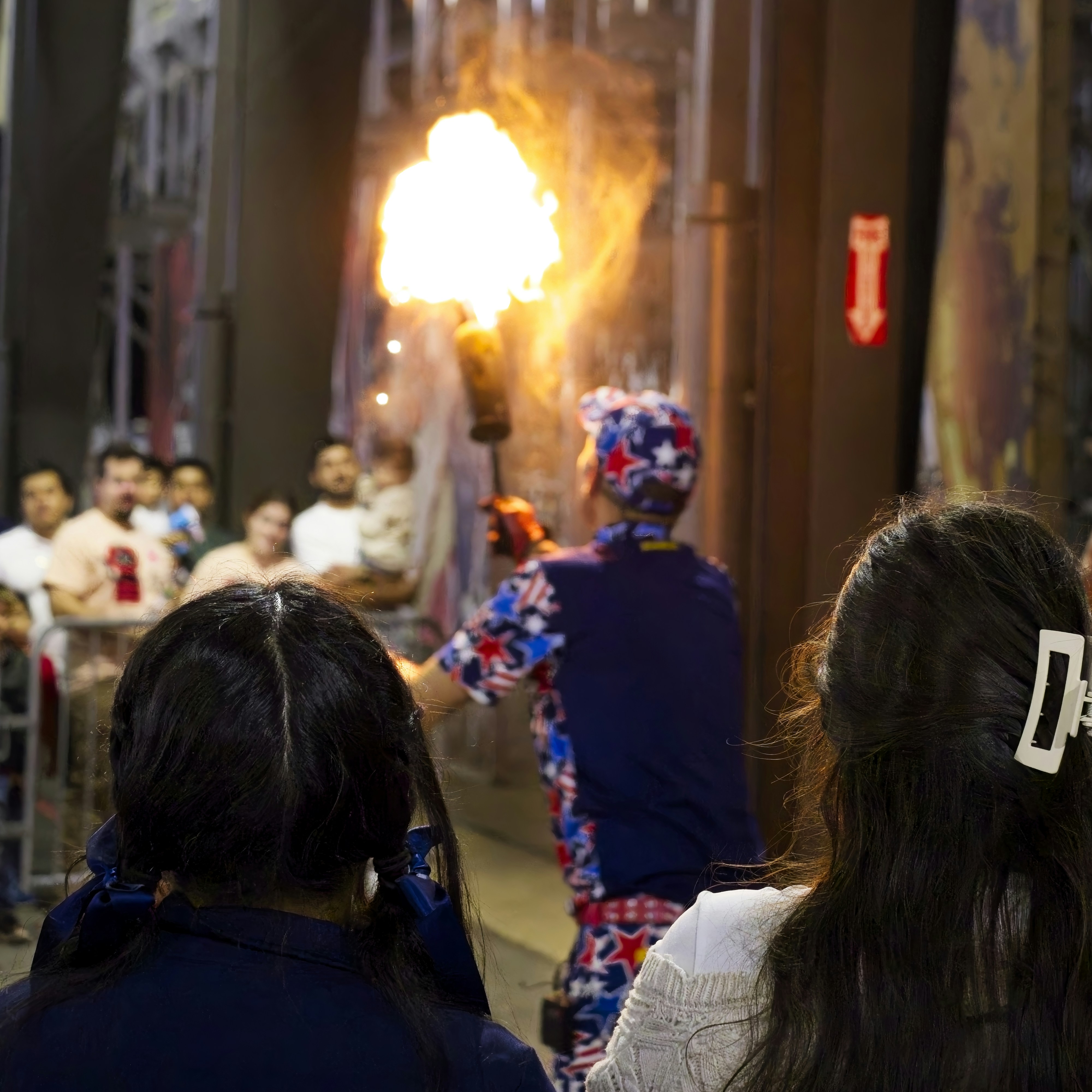 Flame Burst Over the Crowd: The Fire-Tossing Performer Surrounded by Fans