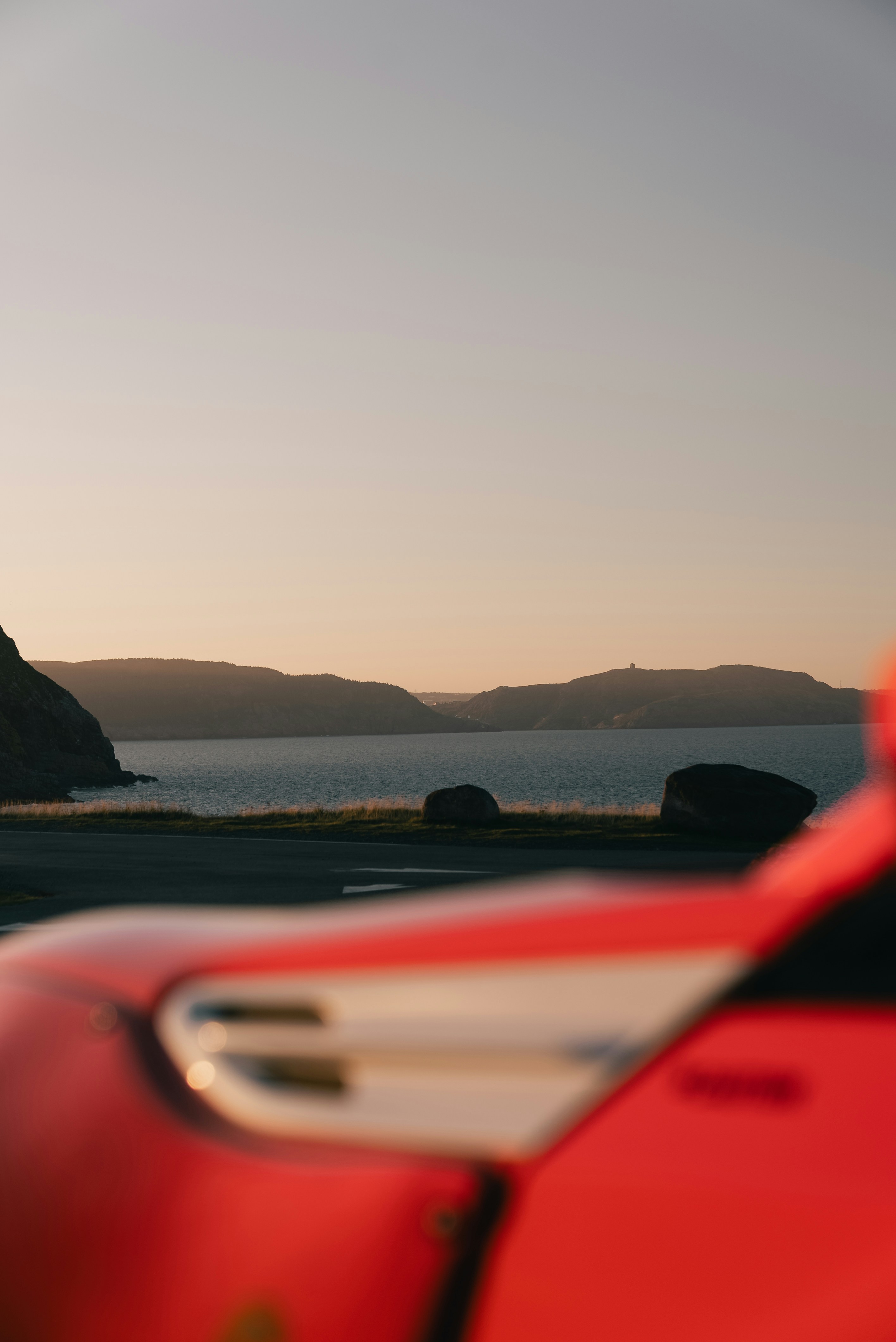 Sunset Serenity Over the Distant Shoreline with a Red Car Frame