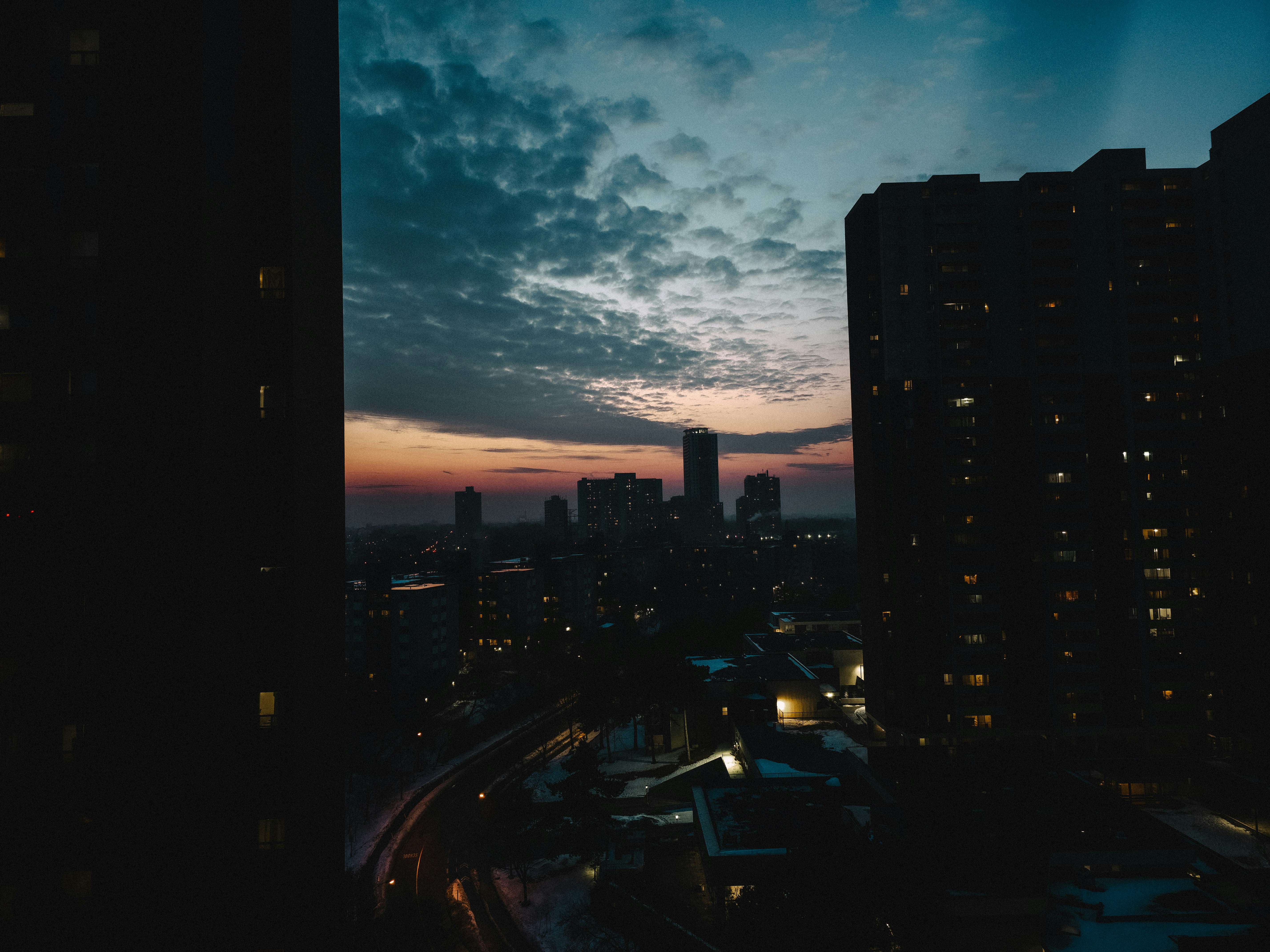 Dusk Over the City: Skyline Framed by Rainy Street Descent