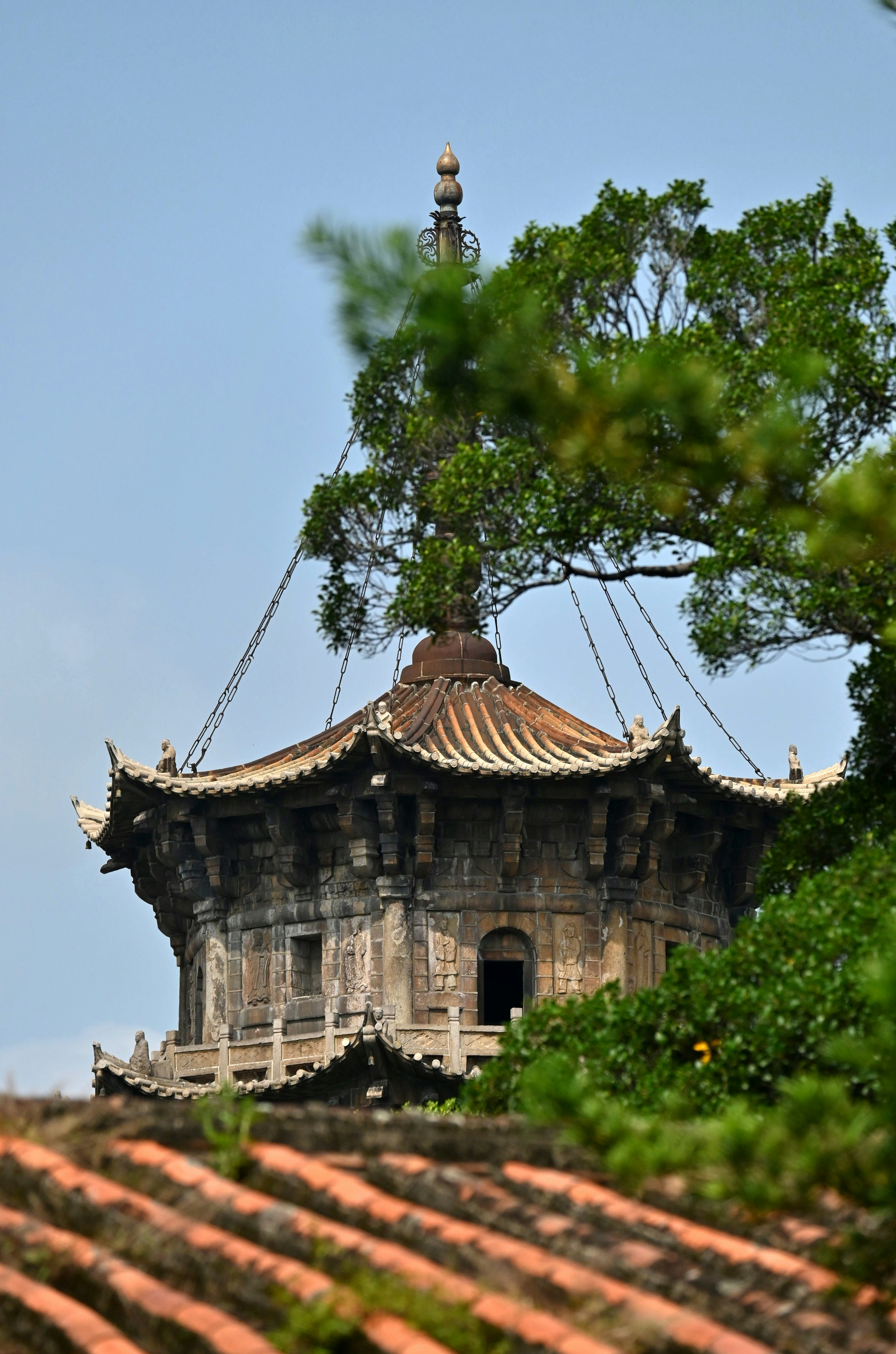 Stone Pagoda Crowned by a Shaded Rooftop Amid Verdant Canopy