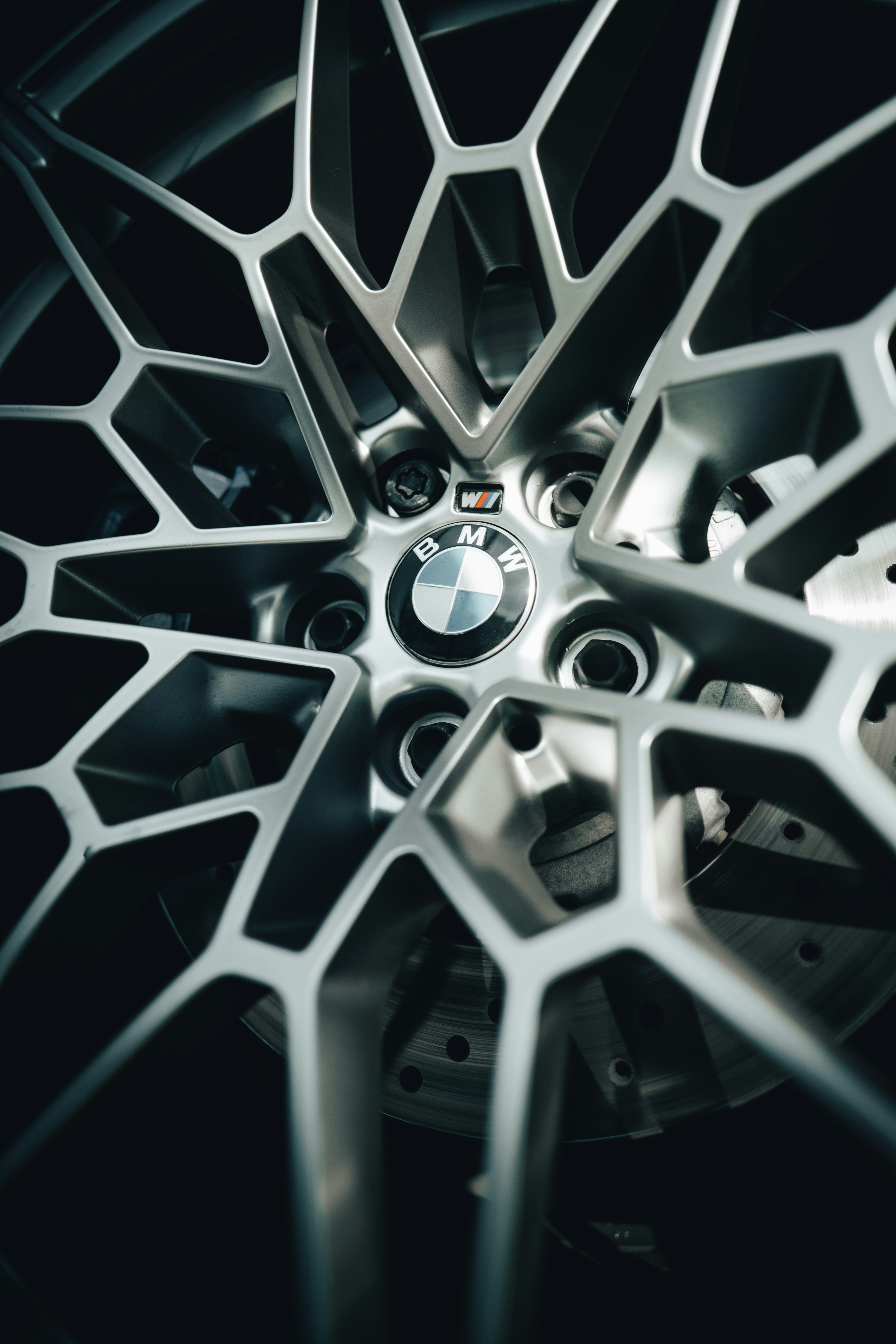 Bentley wheel close-up: A tessellated chrome lattice framing the M badge