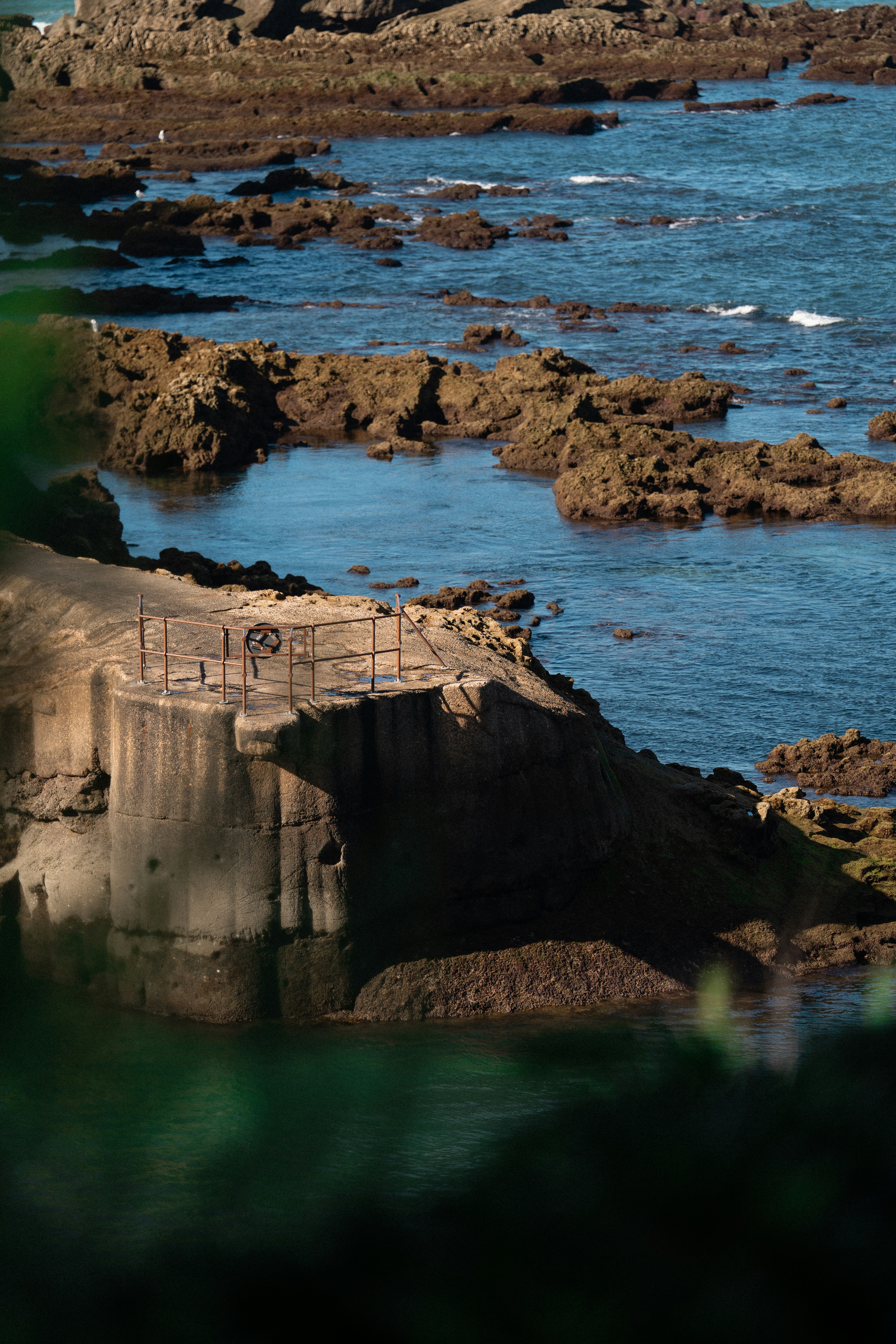 Weathered jetty cradled by tidal blue, a rocky coastline