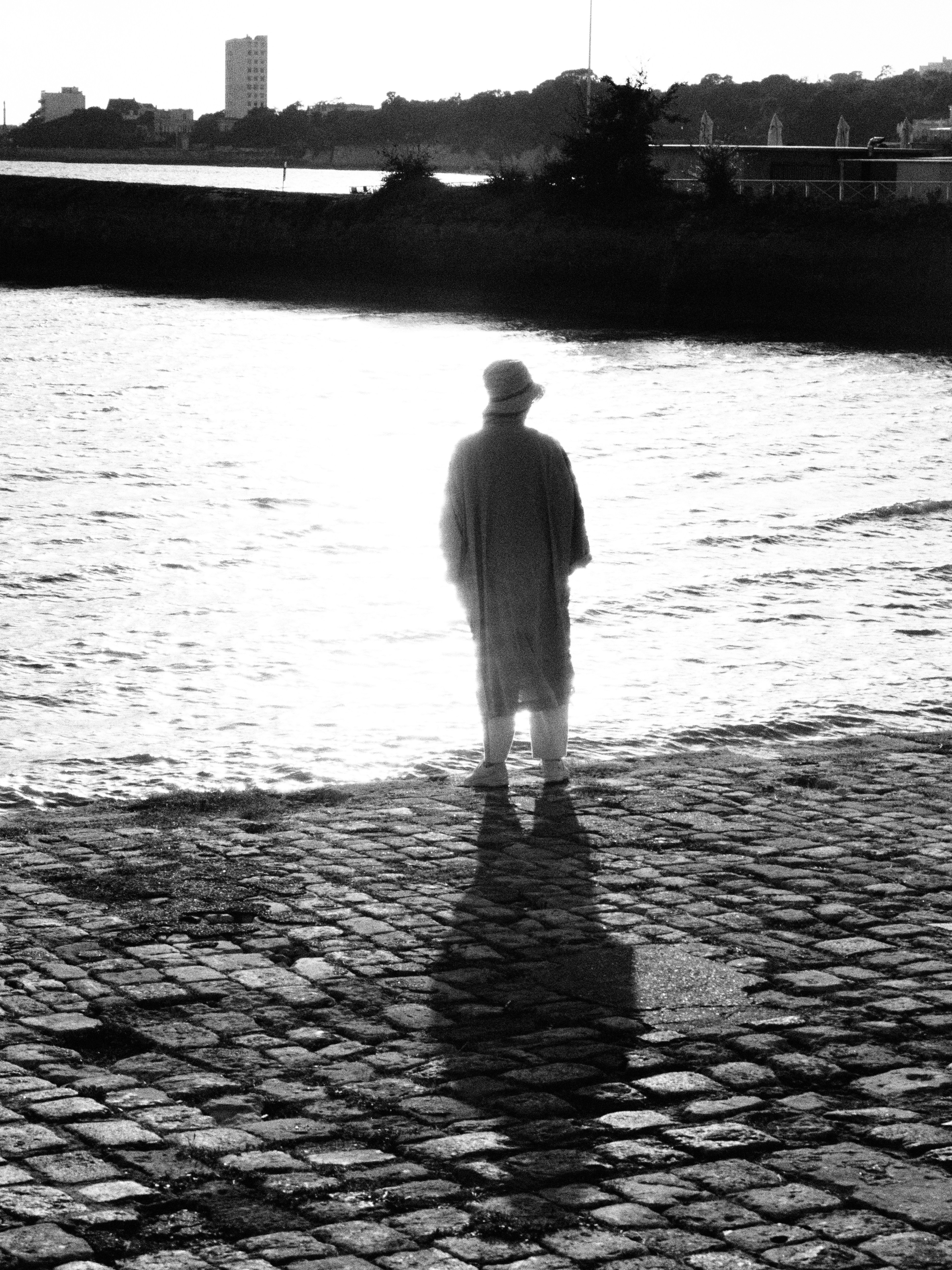 Silhouette by the Shore: A Quiet Figure in Sunlit Mist