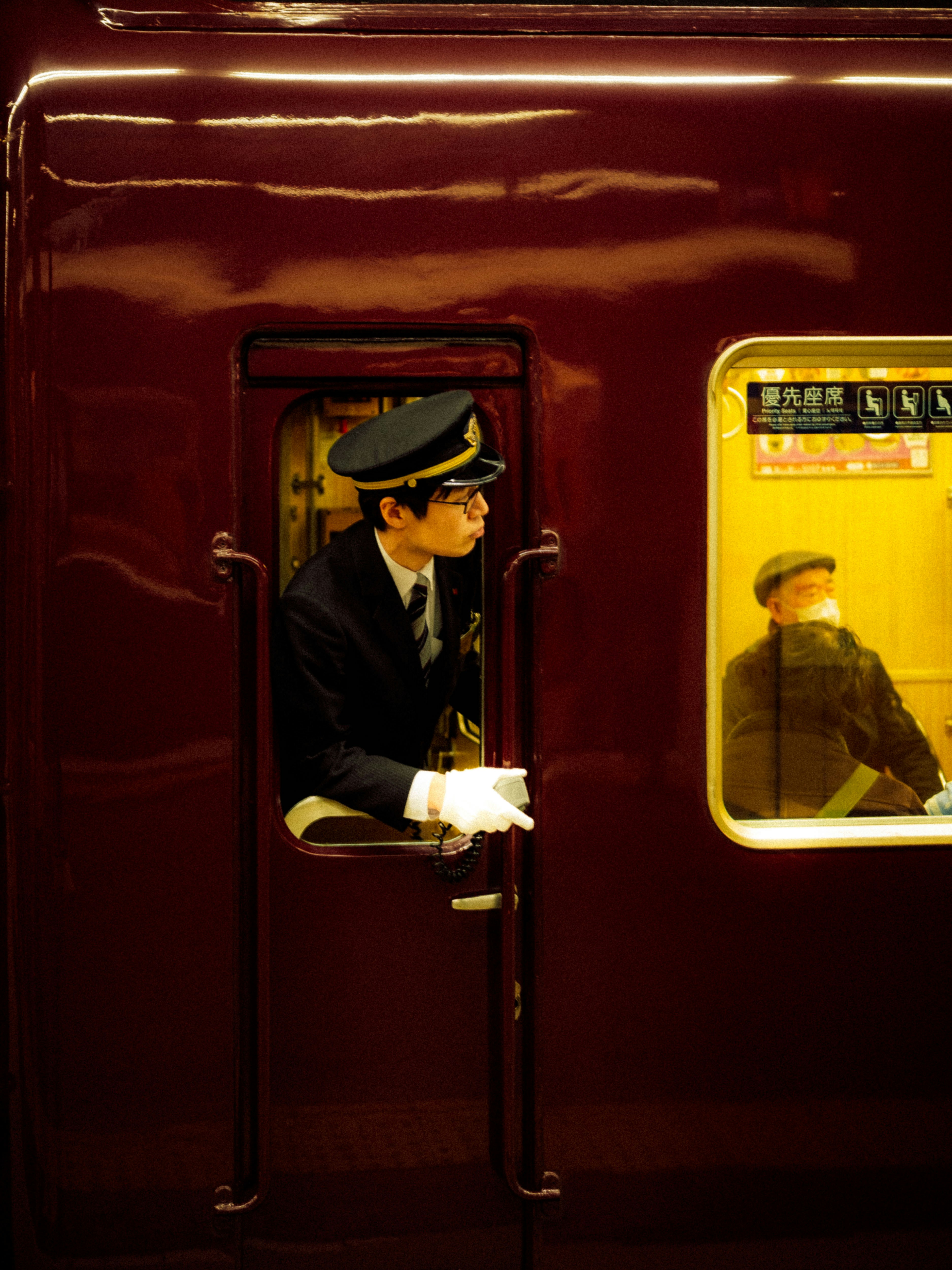 Conductor in Waiting: Portrait of a Train Crewman Gracing a Red Car