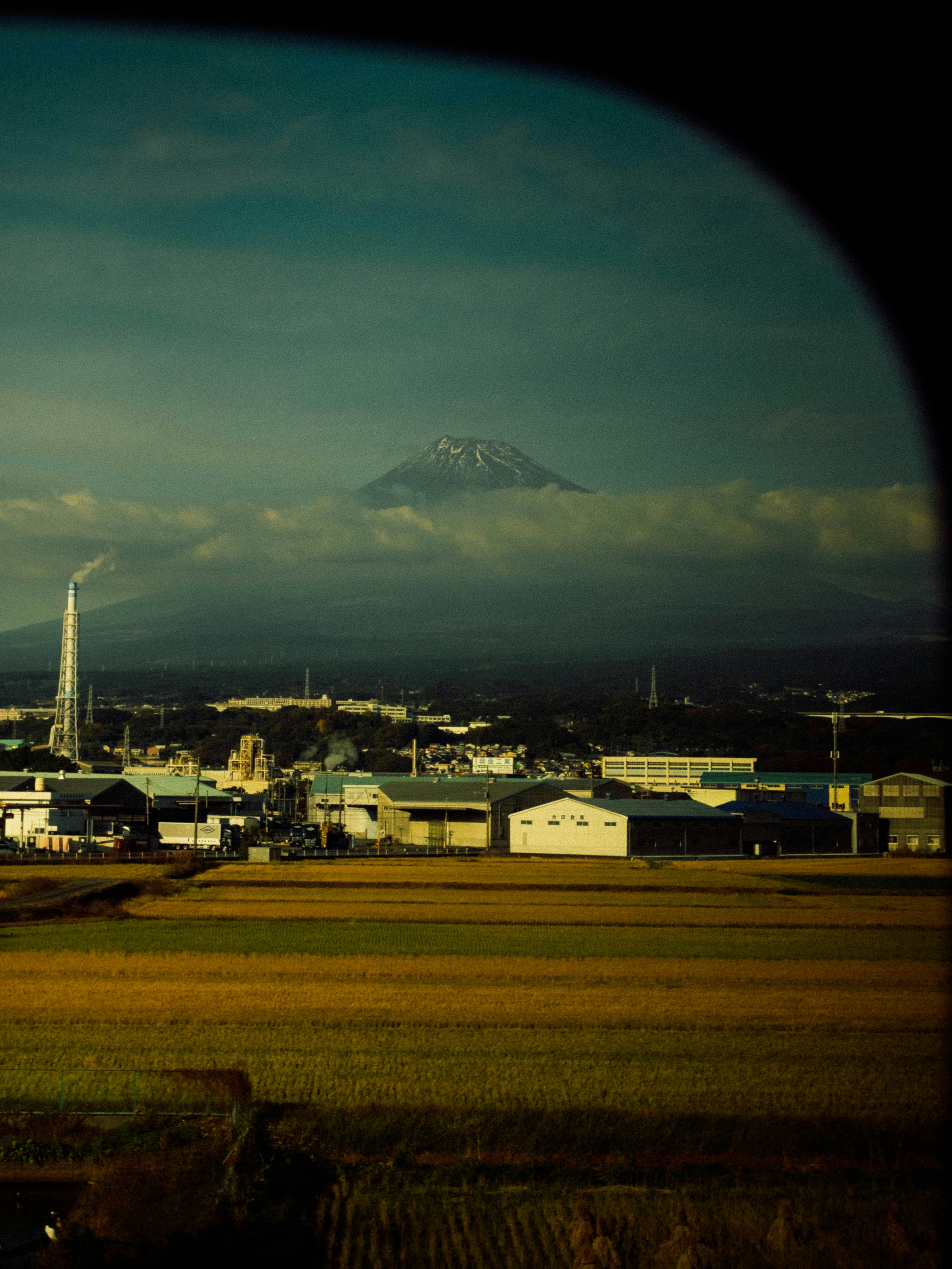 Industrial Horizon Meets Snow-Capped Peak