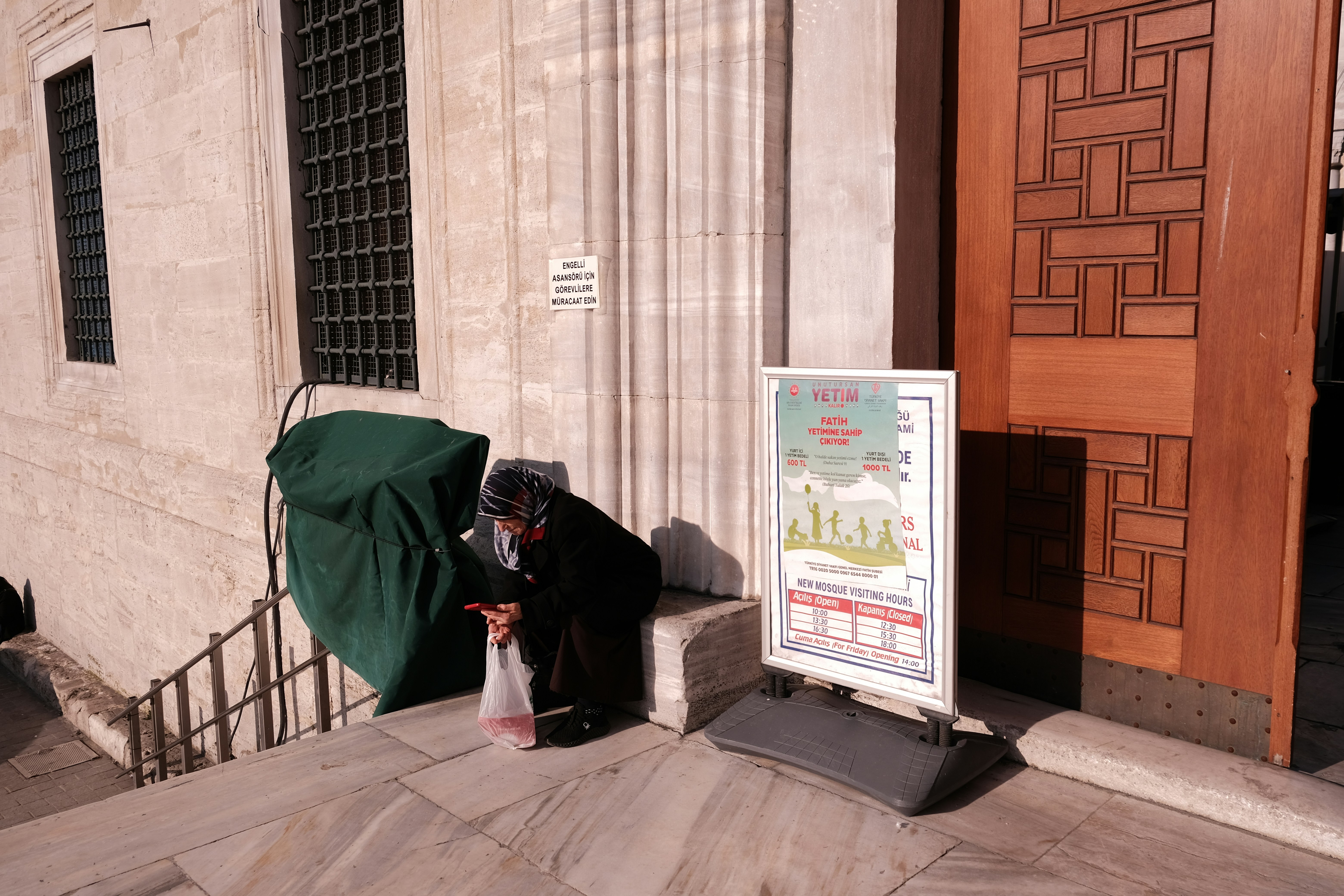 Muted Street Corner: A Figure with Cart Near a Wooden Door