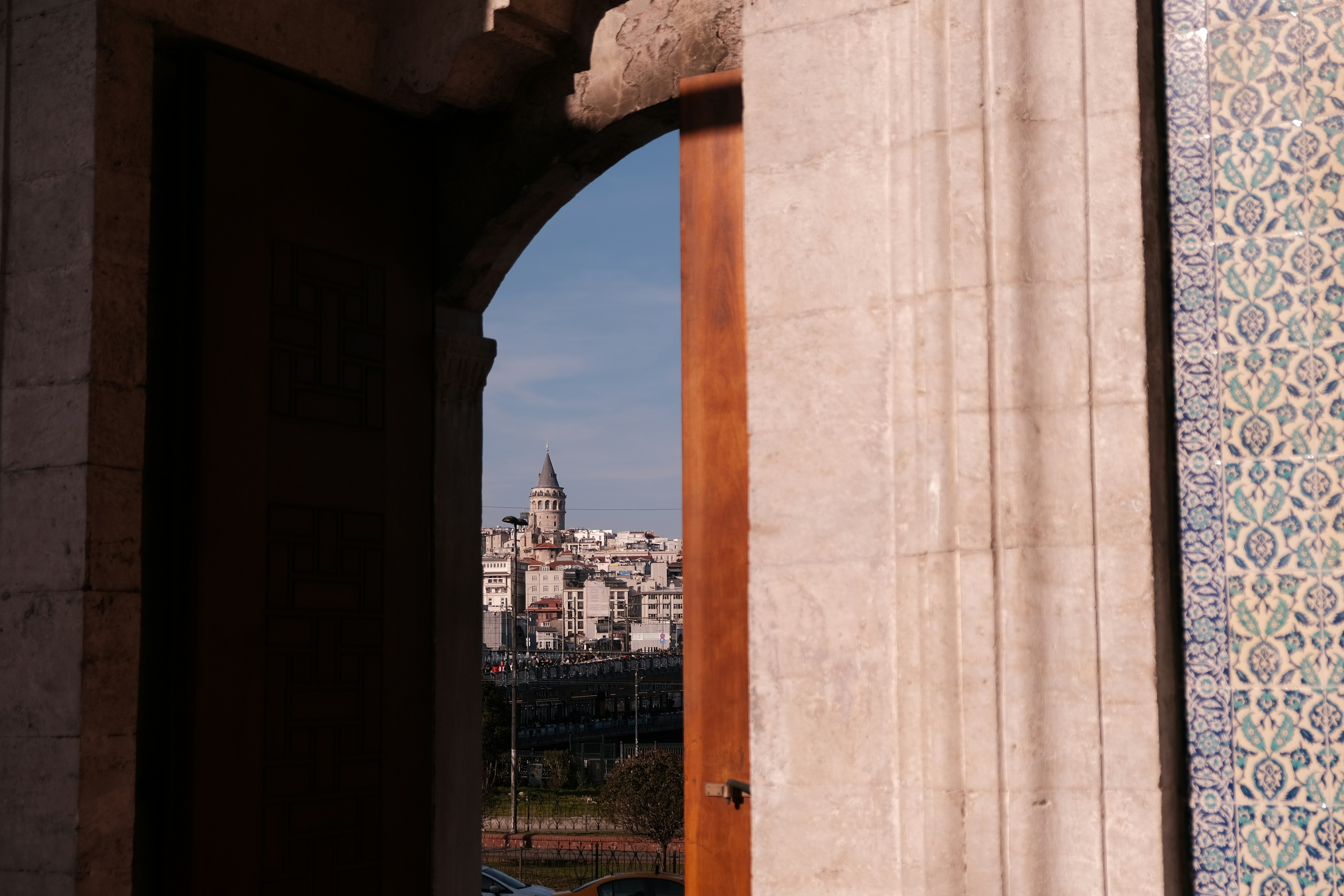 Through the Archway: A City Spire Framed by Stone and Tile