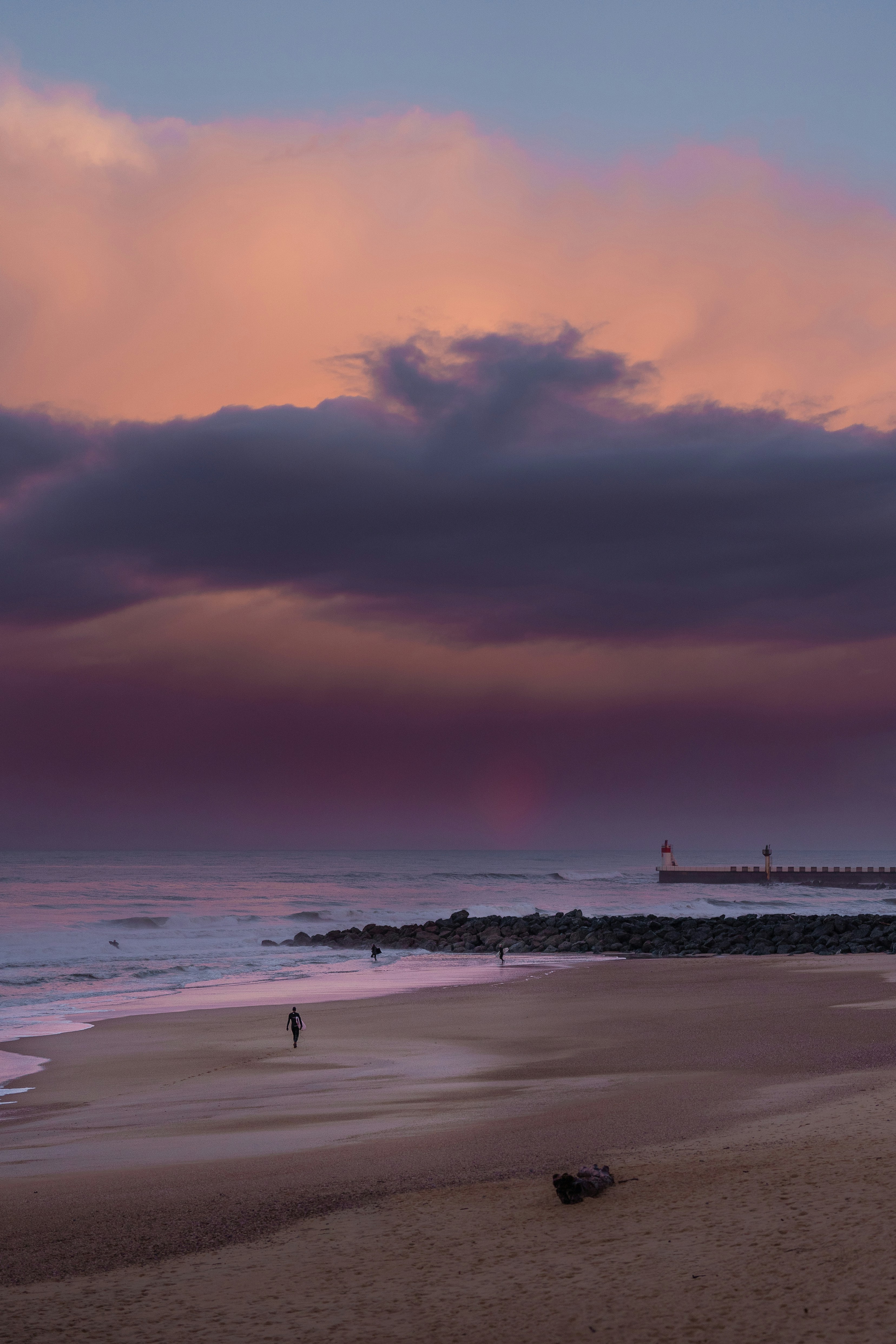 Mist and Neon: A Lone Surfer on Quiet Sands at Dusk
