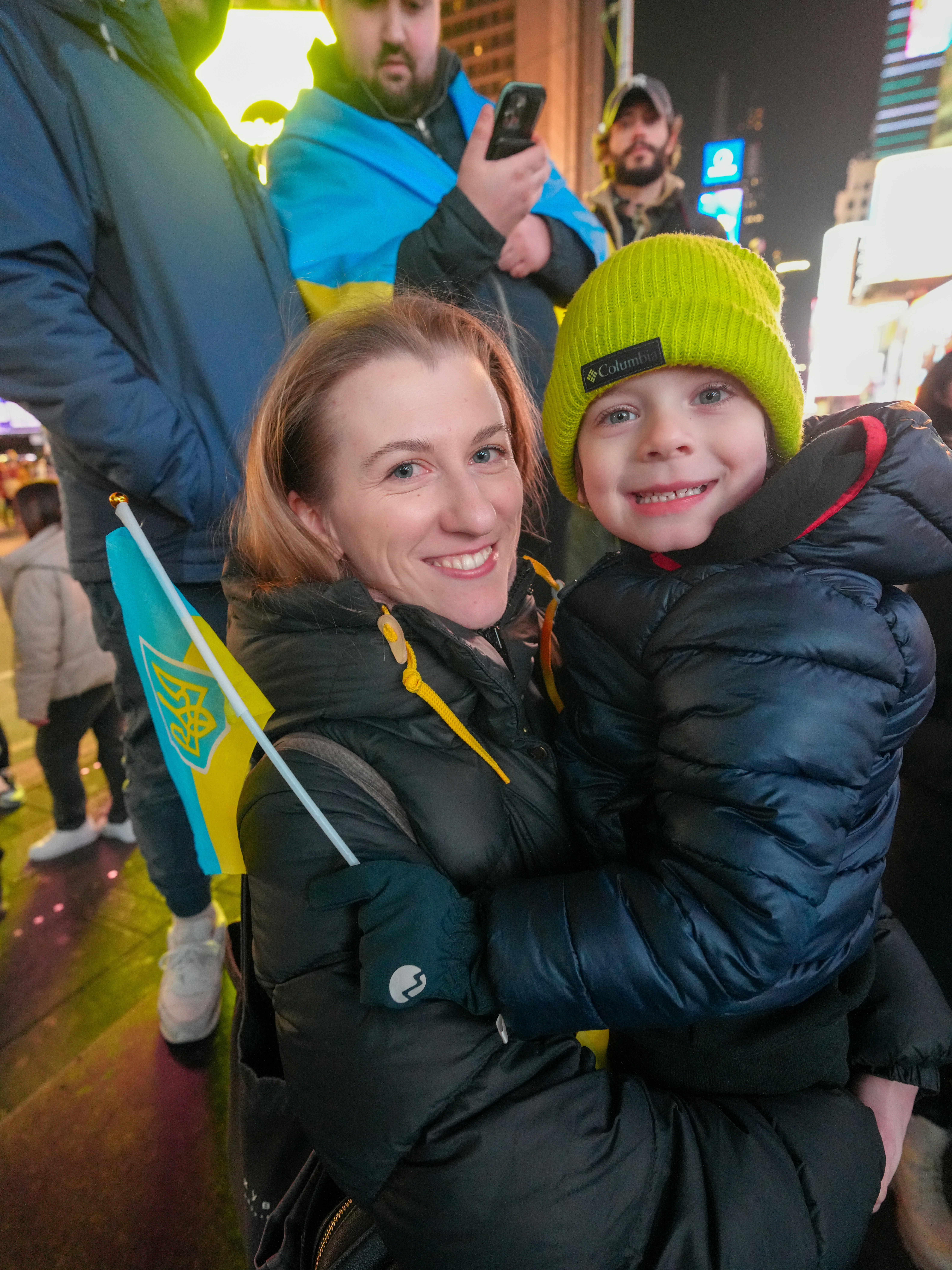 Warm Embrace in Times Square: A Mother and Child Amid Neon Lights