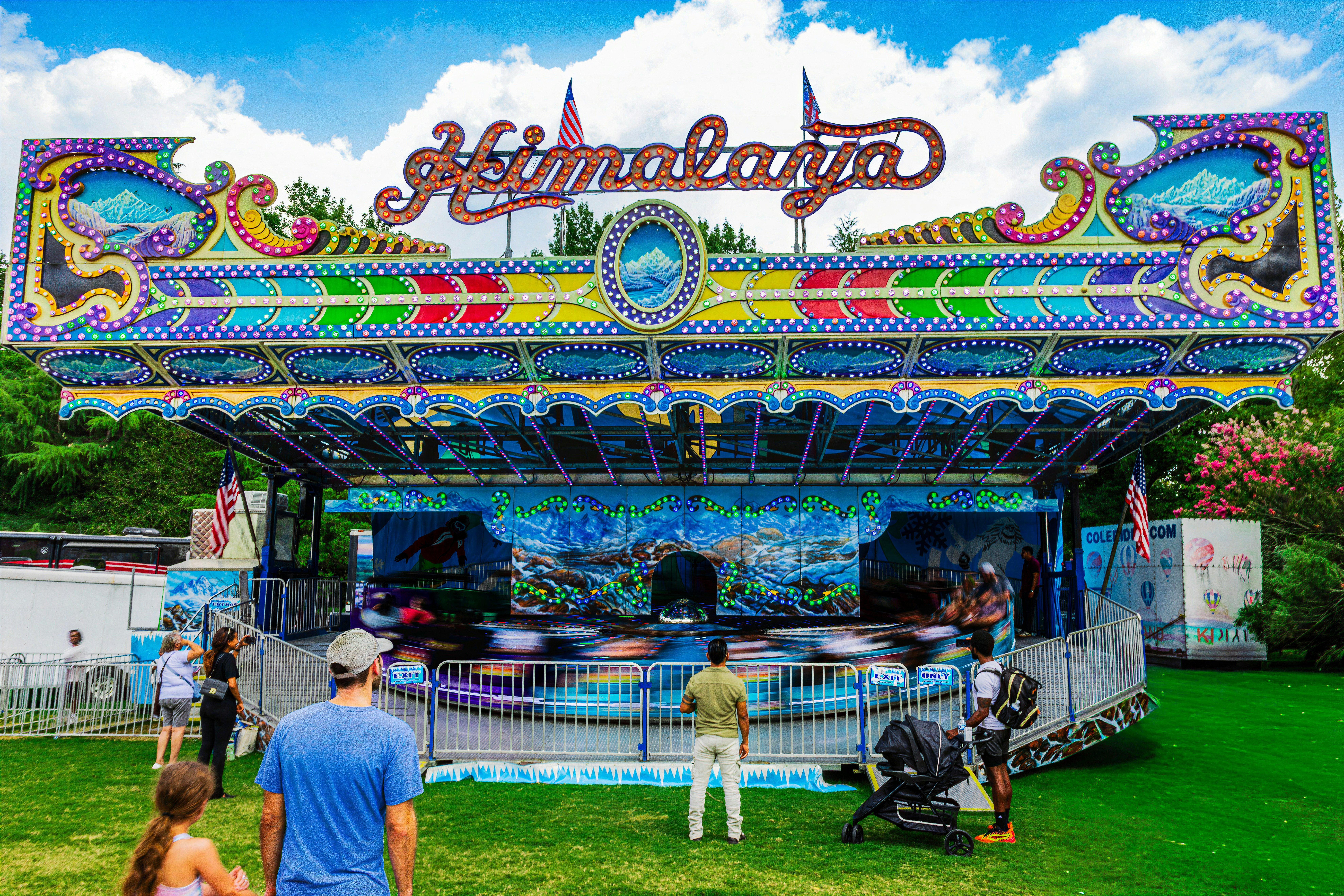 Neon Carousel Gate: A Colorful Carnival Entrance Framed by Lively Faces and Lights