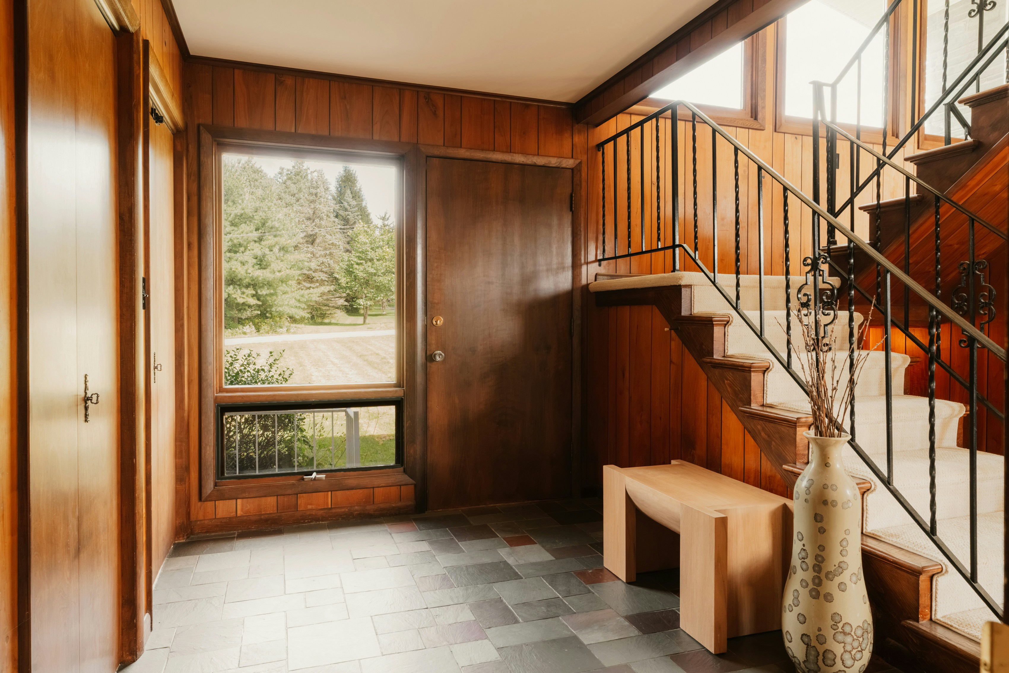 Mid-Century Hallway: Warm Wood, Stairs, and Light from the Door
