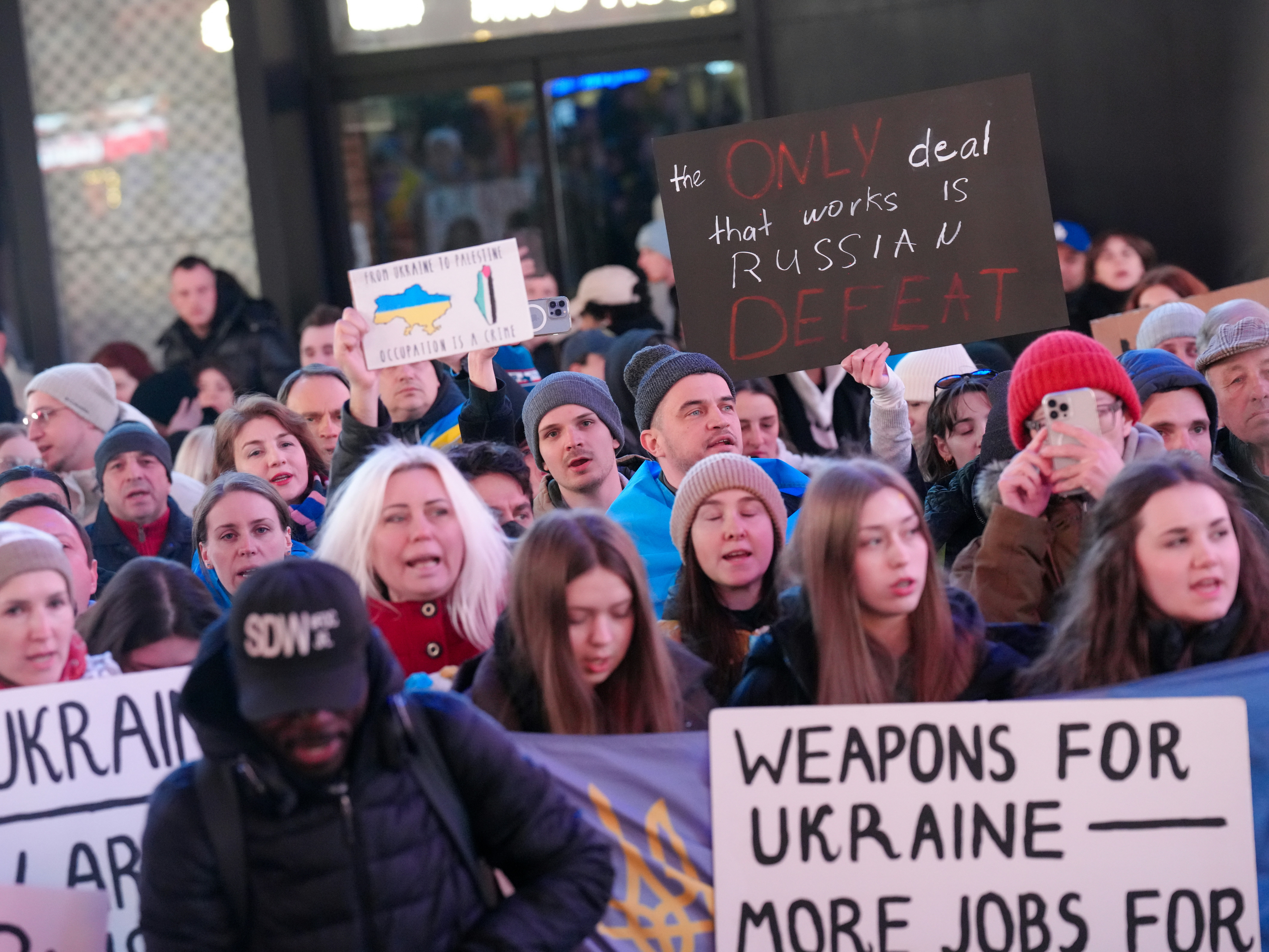 Hands Up for Ukraine: A Diverse Crowd Holds Signs at a Peaceful Rally