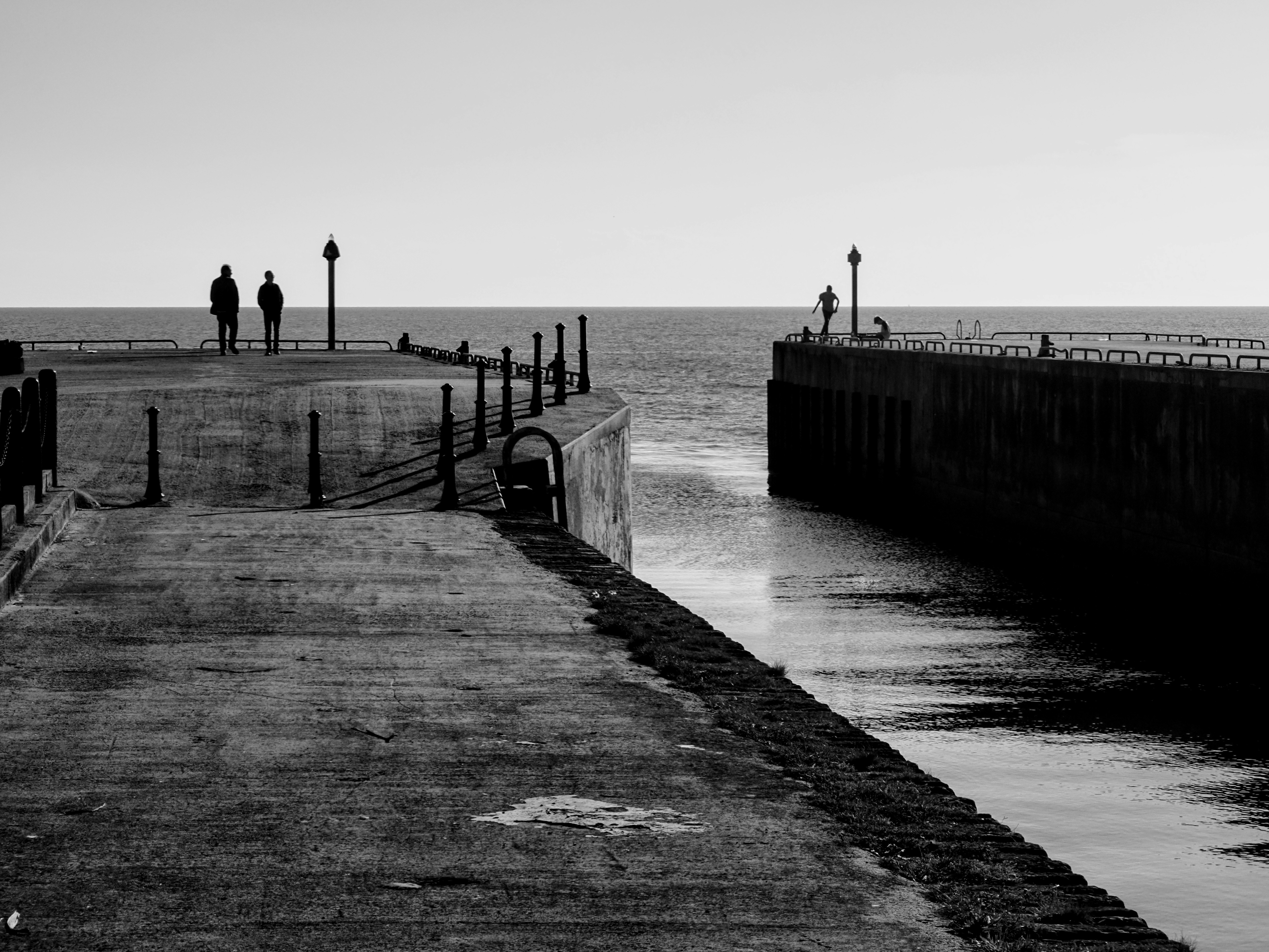 Harbor Promenade at Dusk: Lone Figures at the Pier