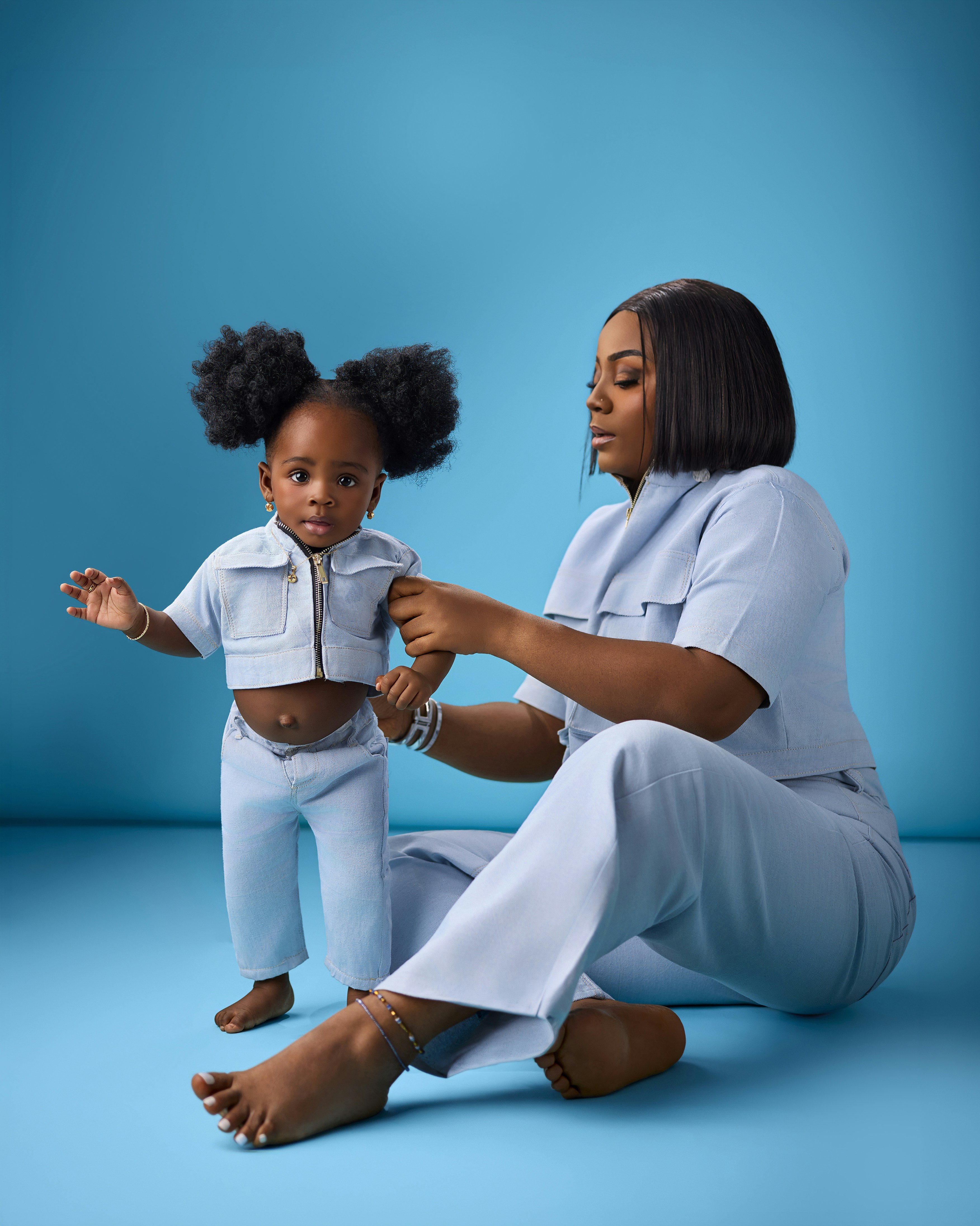 Mother and Child in Soft Blue: A Quiet Bond Against an Ocean of Cyan